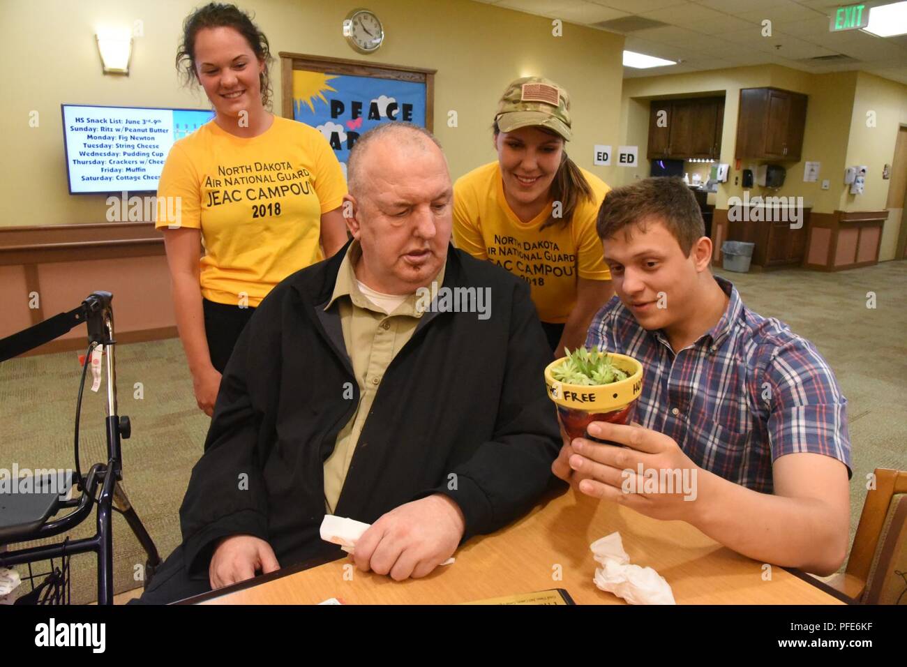 U.S. Air Force Airman 1st Class Jordan Paxton, right, presents a potted ...