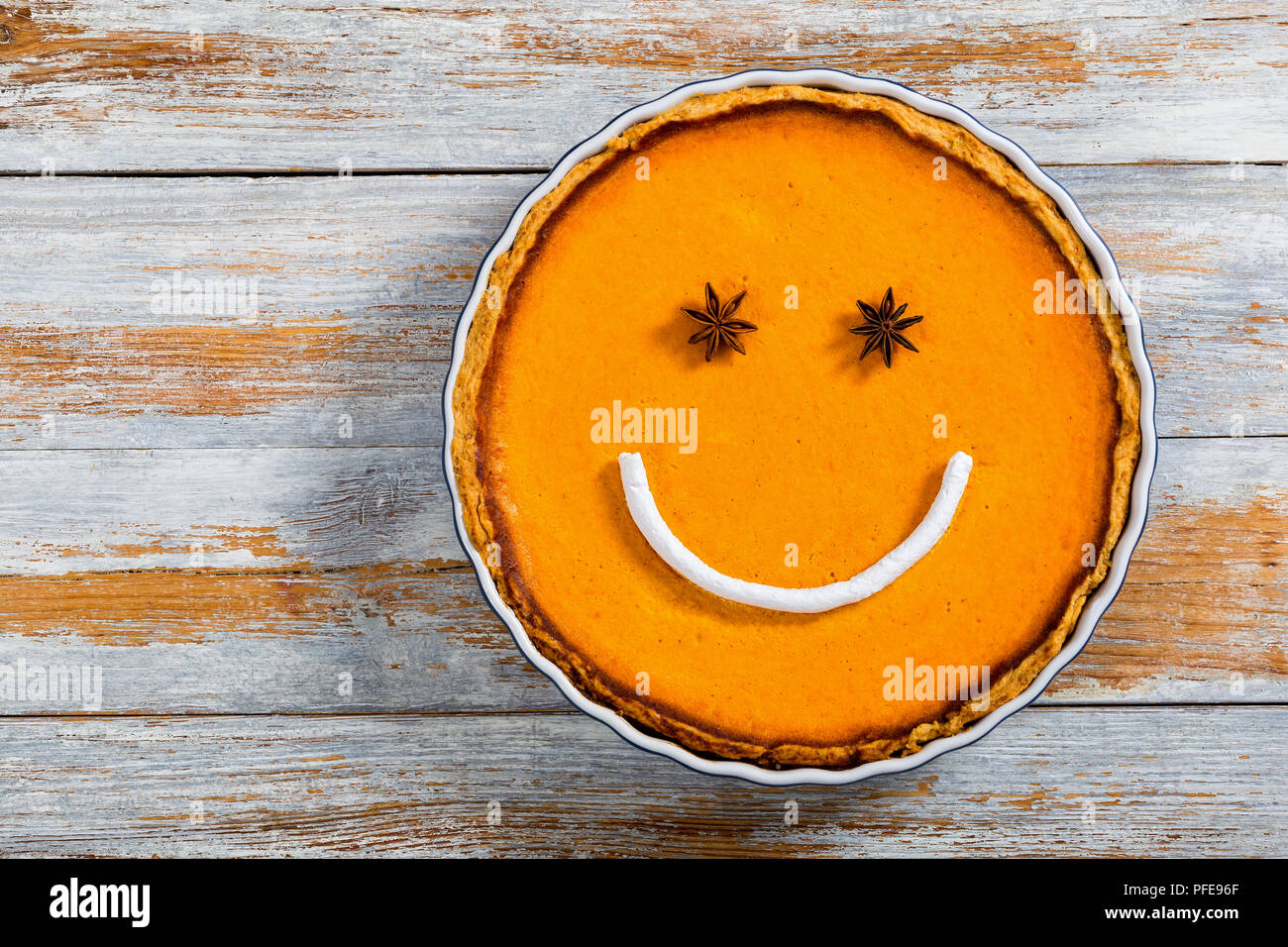 American pumpkin pie topped with whipped cream in the form of a smiling ...