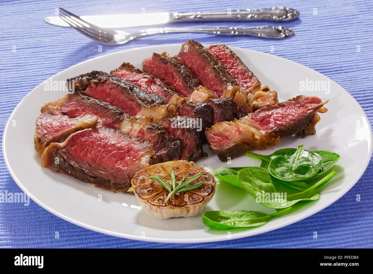 hot beef rib-eye meat juicy steak, medium rare, cut in slices on white ...