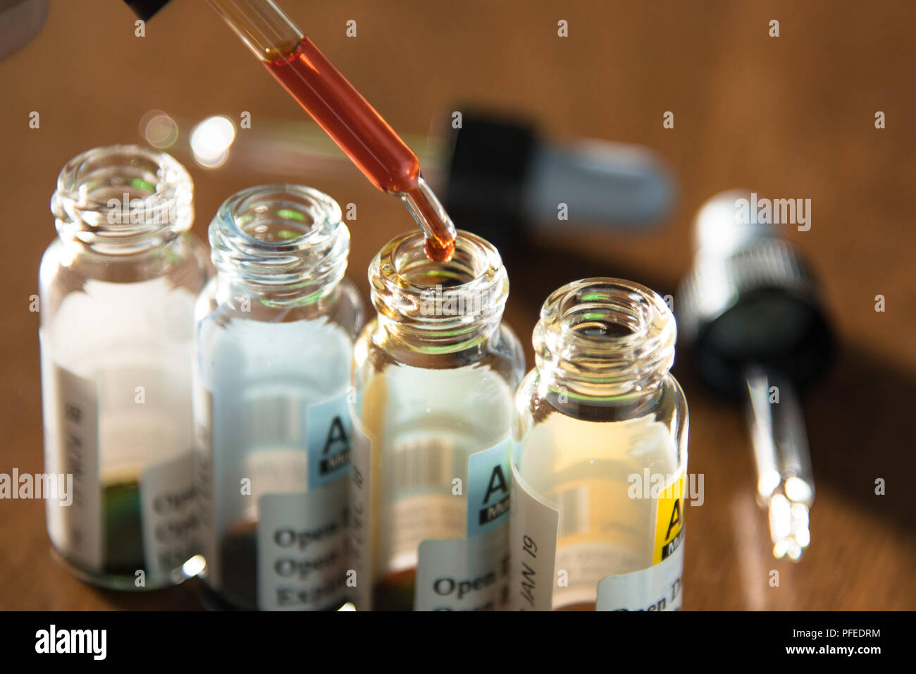 Laboratory glass items adding drop to one of several test tubes. A ...