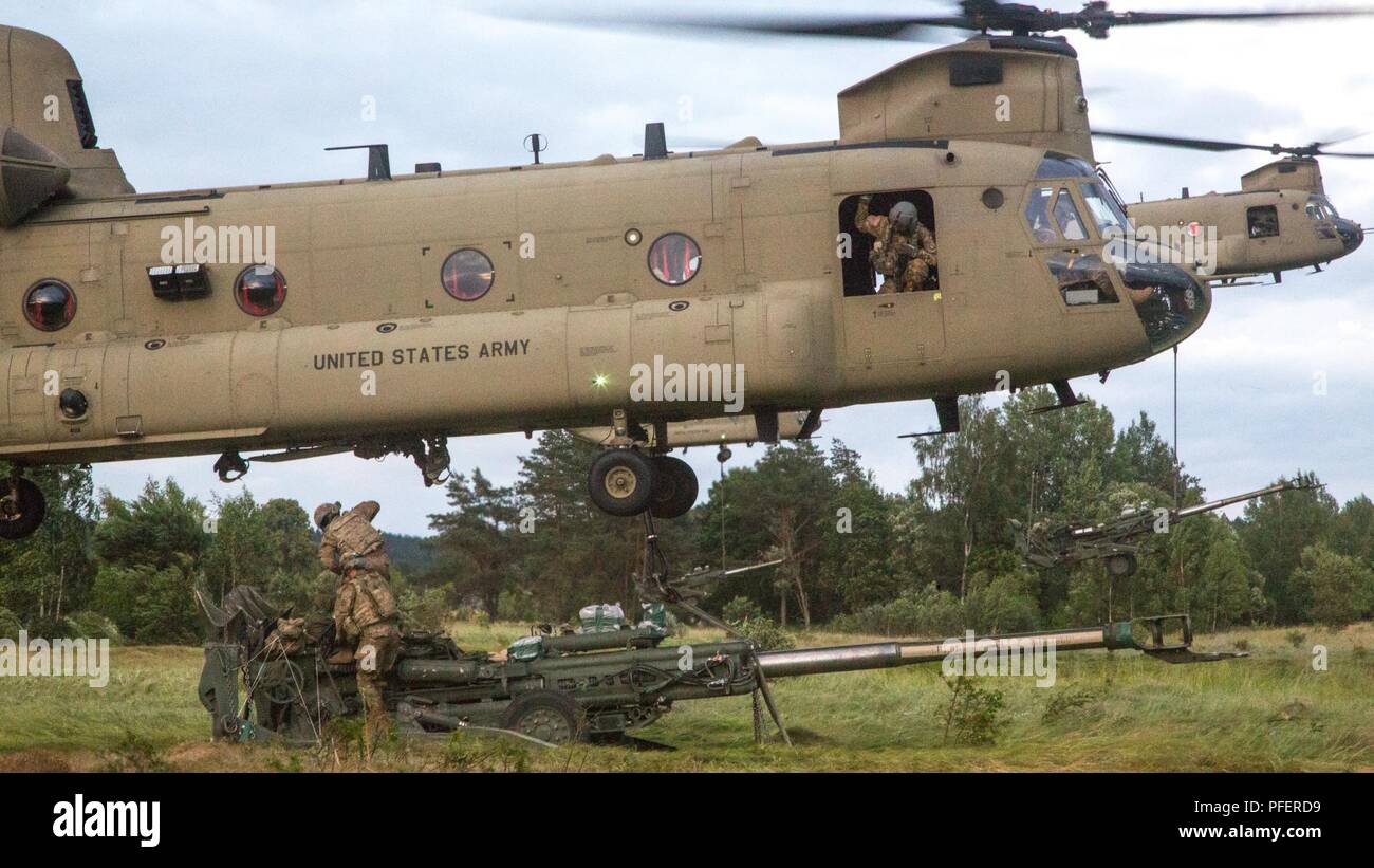 U.S. Army Soldiers assigned to the 2d Cavalry Regiment, attach an M777A2 155mm howitzer to a CH ...
