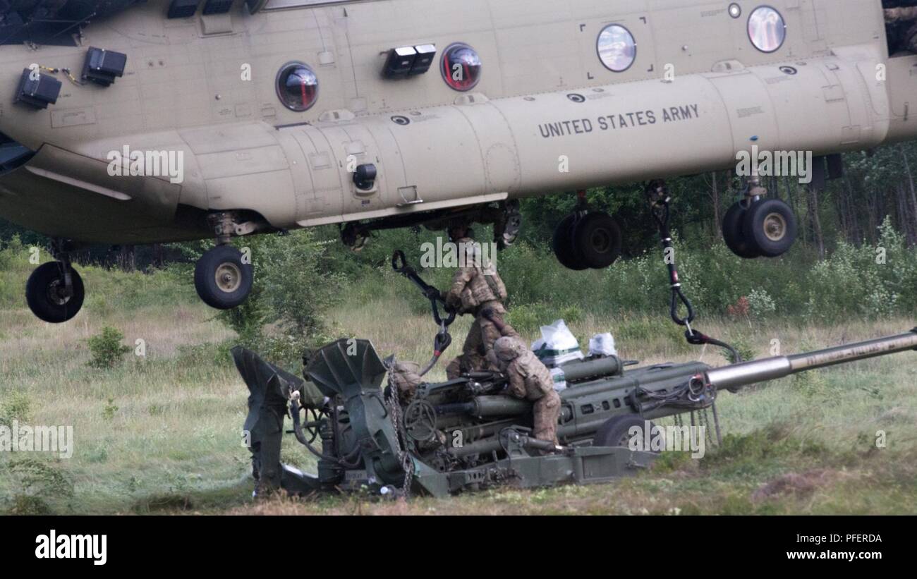 U.S. Army Soldiers assigned to the 2d Cavalry Regiment attach an M777A2 155mm howitzer to a CH ...