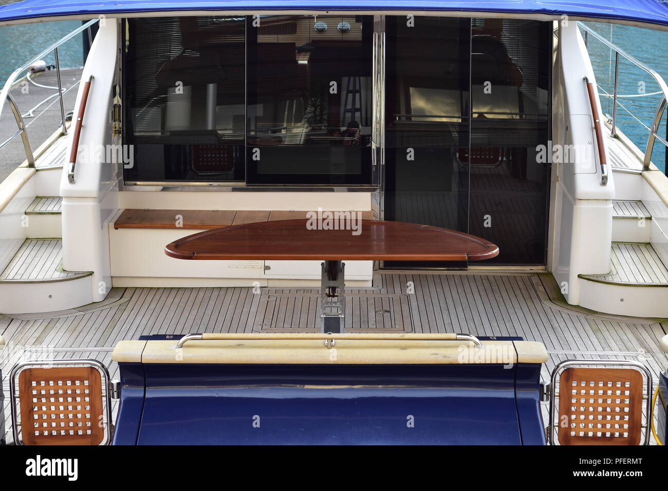 Wide stern deck with outdoor table and tinted glass door of large ...