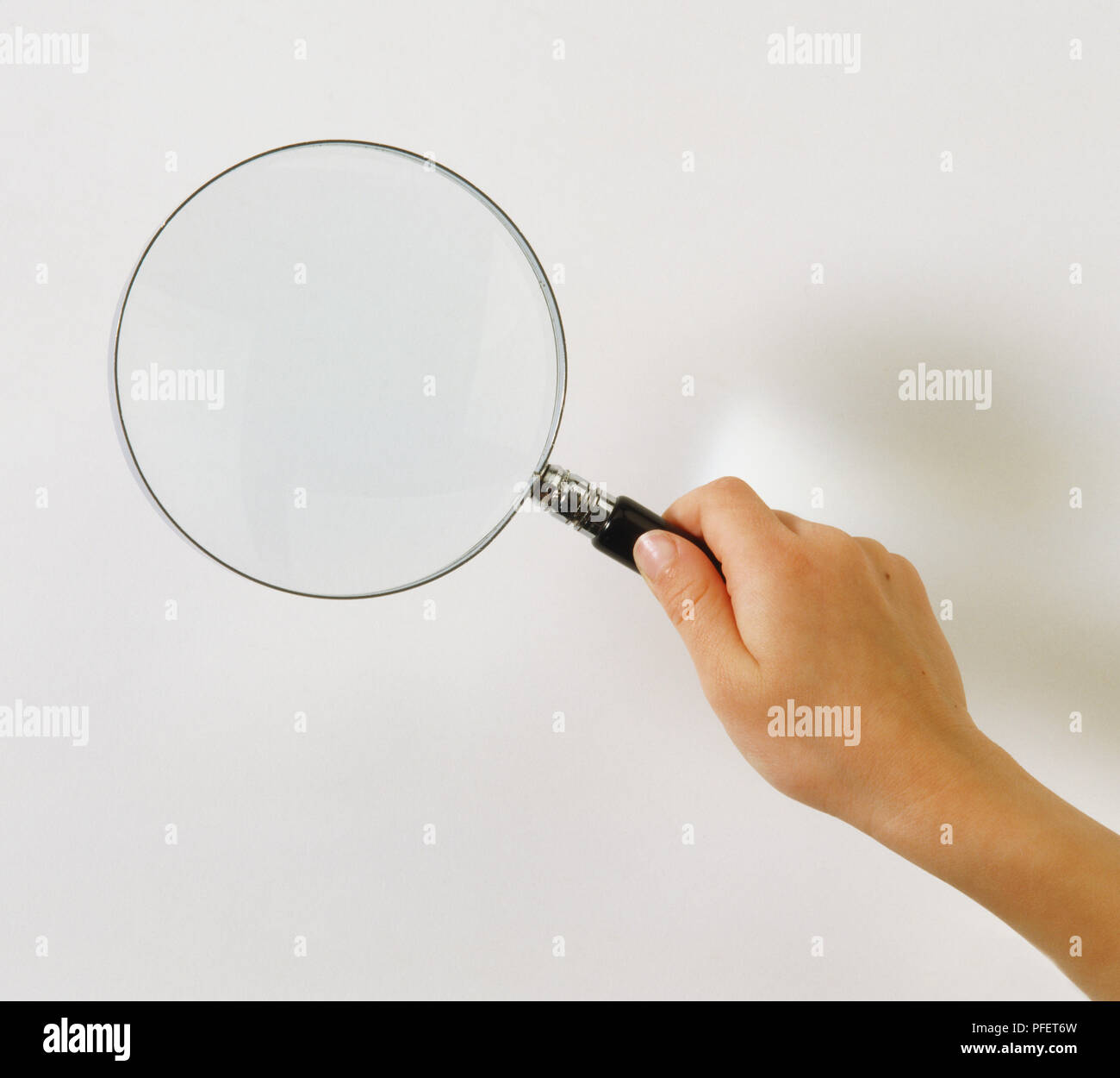 Hand holding a magnifying glass Stock Photo - Alamy