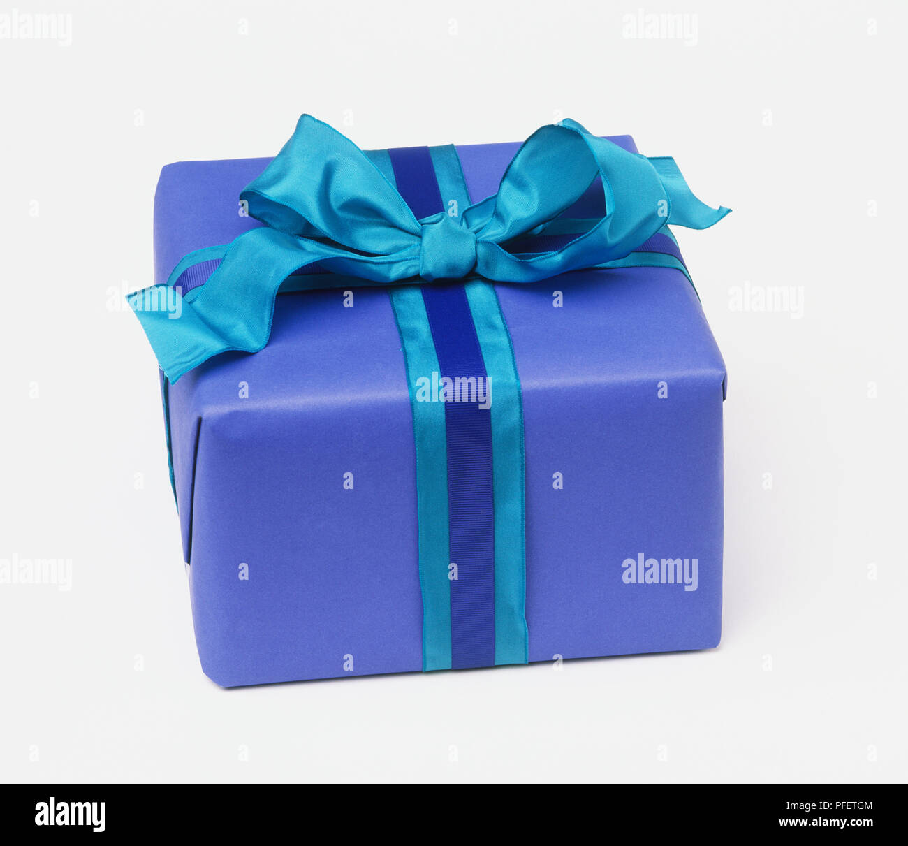 Square shaped gift wrapped with blue paper and blue ribbon Stock Photo ...