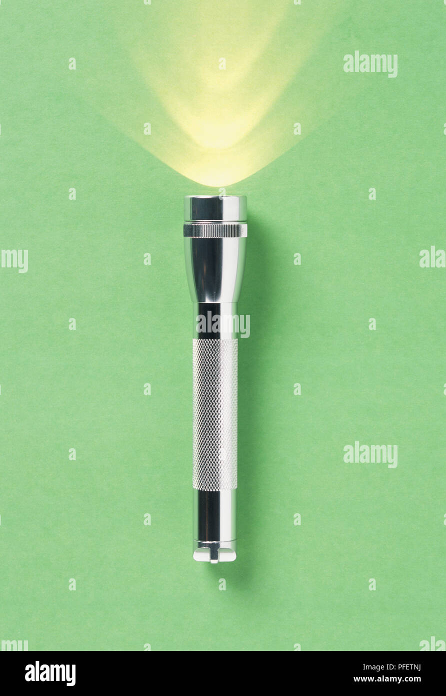 A lit compact silver torch, side view Stock Photo - Alamy