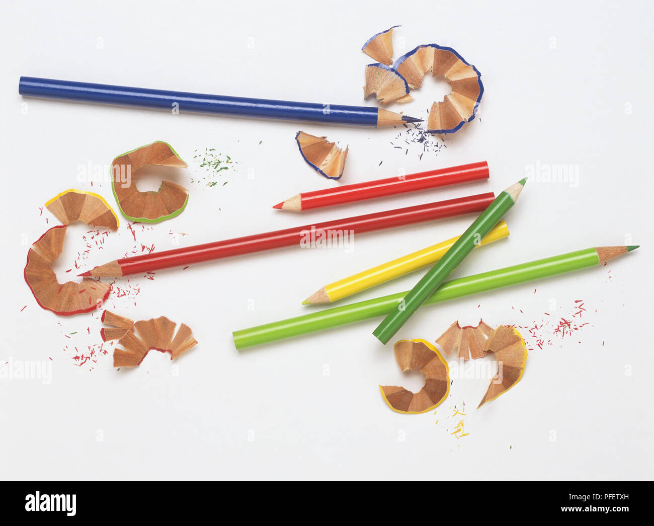 Several scattered tapered colouring pencils surrounded by sharpenings ...