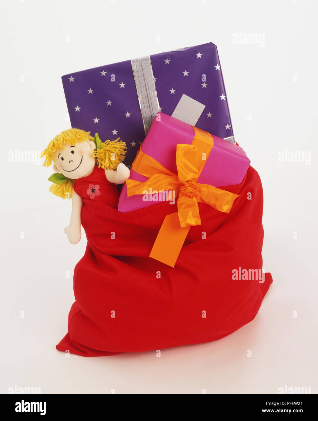 Red gift sack filled with wrapped boxes and rag doll Stock Photo - Alamy