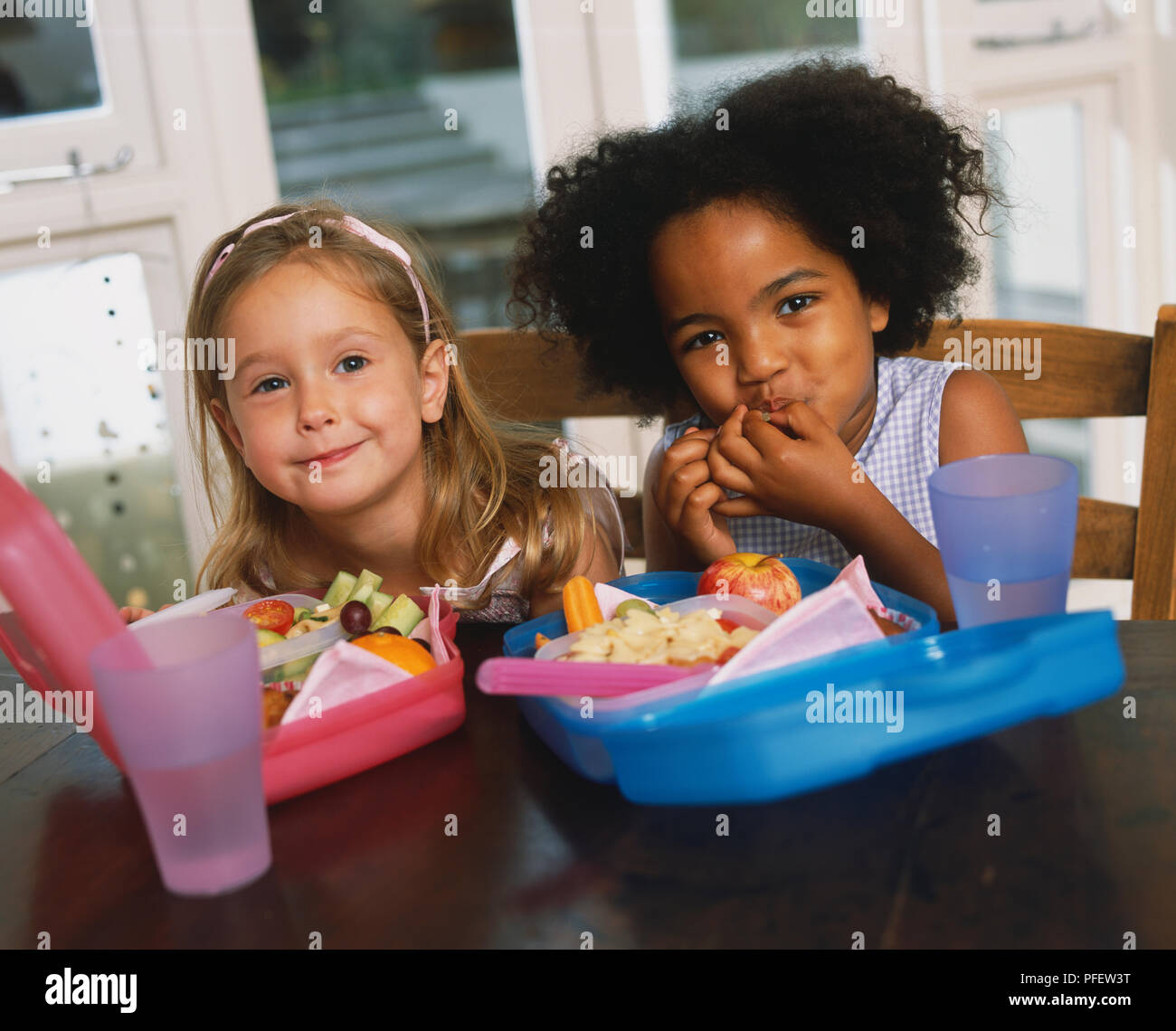 Two girls sitting eating their packed lunch Stock Photo - Alamy