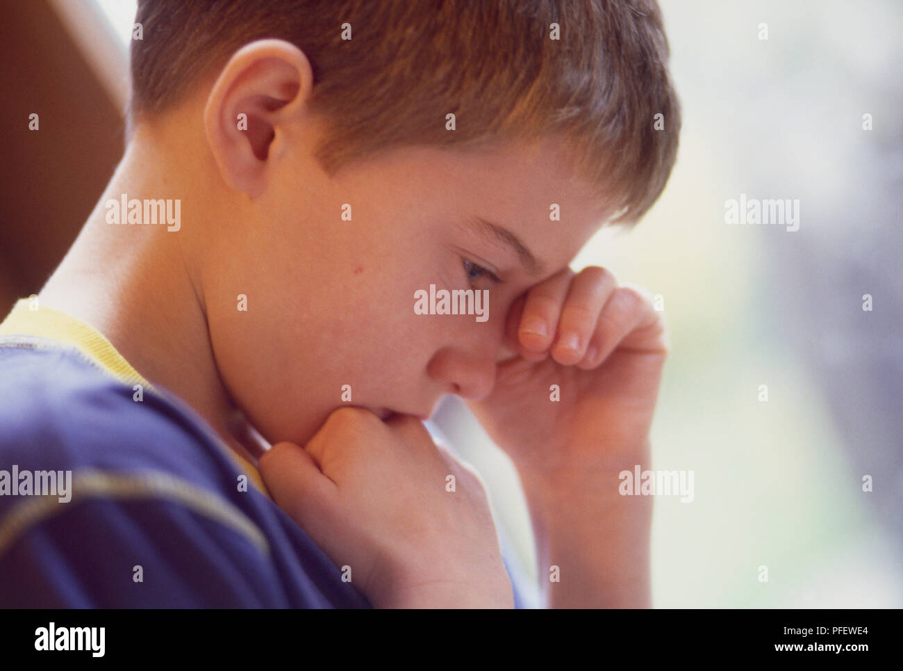 Boy hand in his mouth, holding his nose, side profile, close up Stock ...