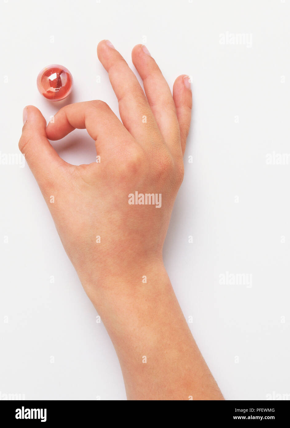 Hand poised to snap out index fingers and hit glass marble, view from ...