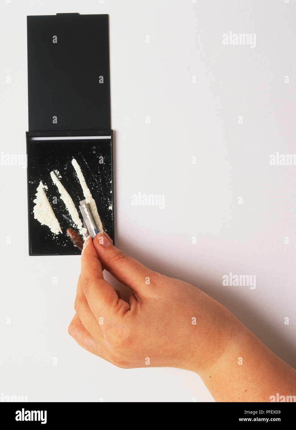 Using a razor blade to arrange powder in to lines on a ceramic surface ...
