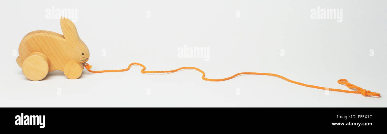 Wooden toy rabbit on wheels attached to towing string, side view Stock ...