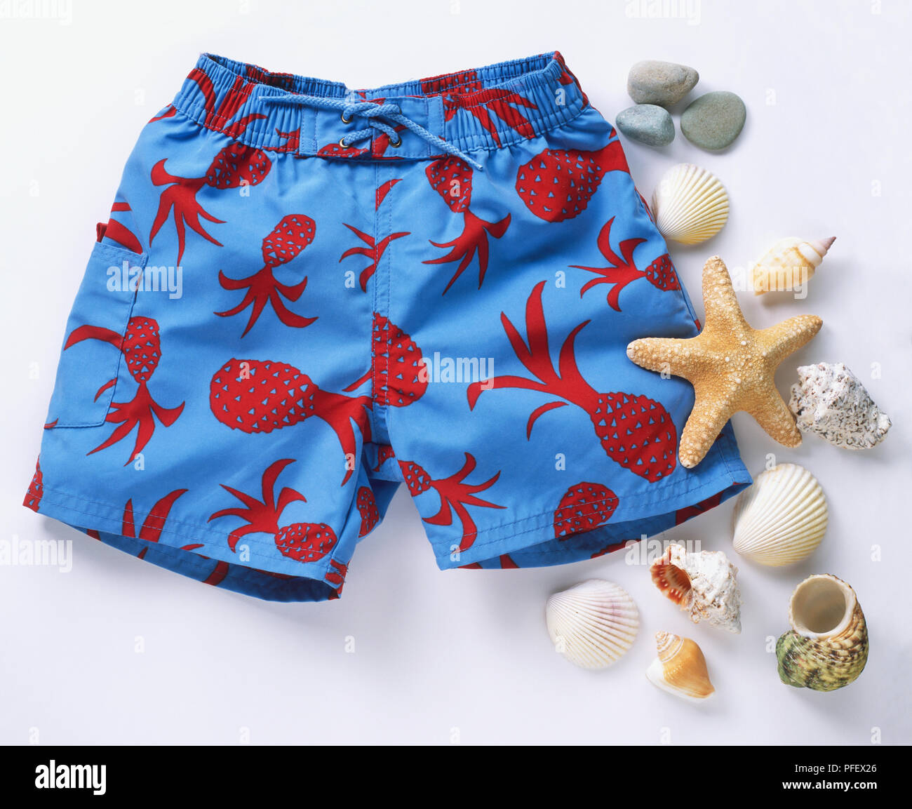 Colourful pair of swimming trunks and selection of seashells Stock ...