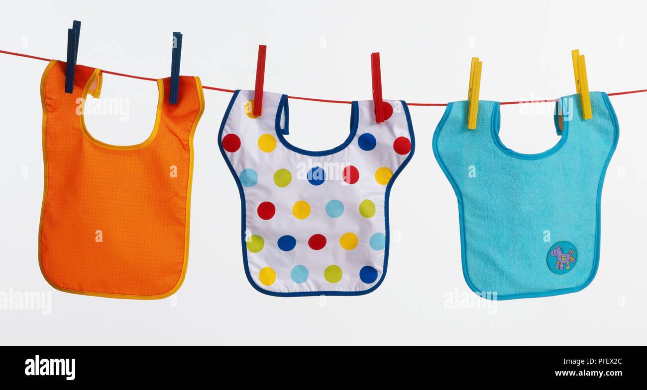 Three colourful bibs hanging on washing line, front view Stock Photo ...