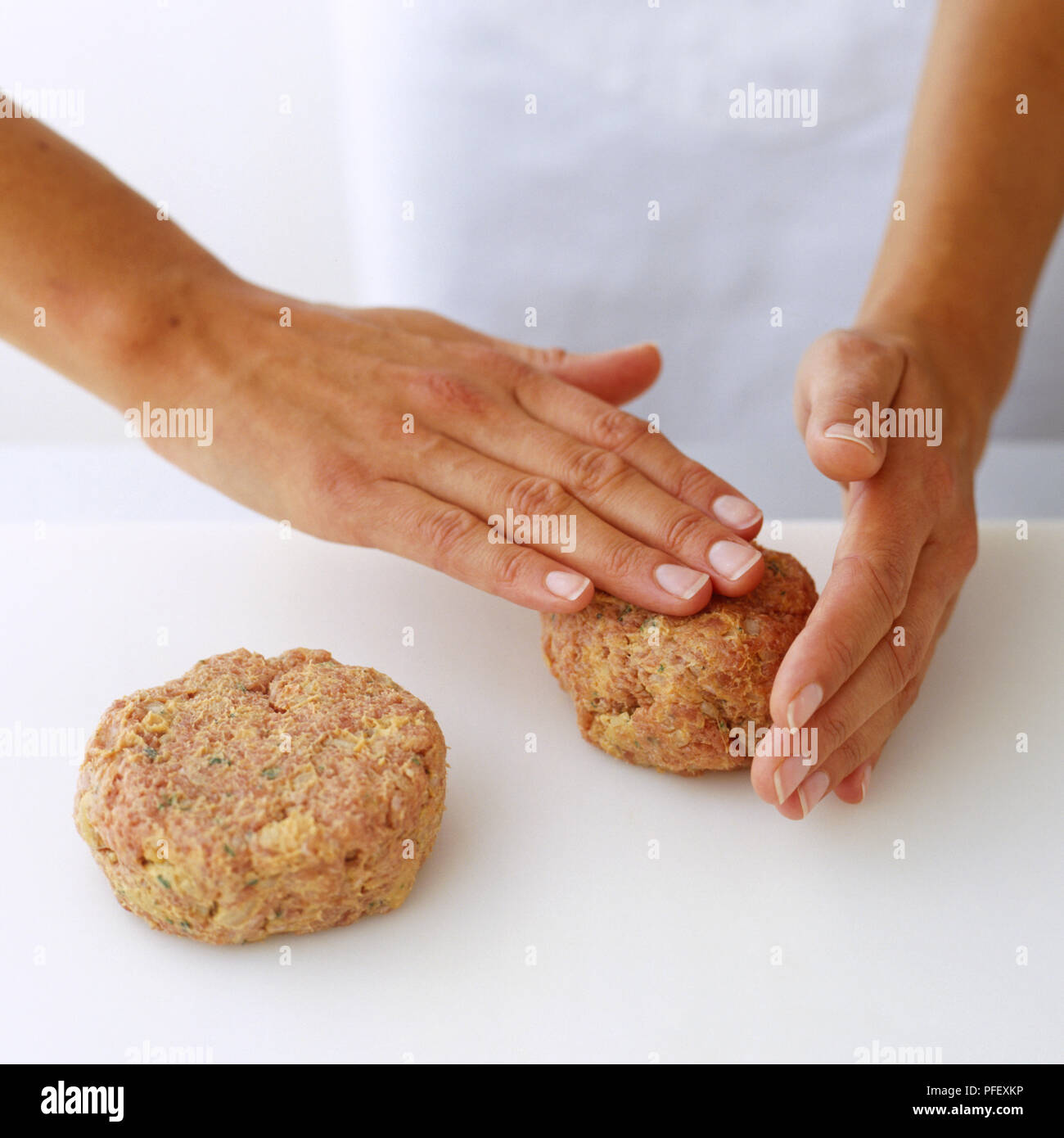 Minced meat rolled into balls and patted flat Stock Photo - Alamy