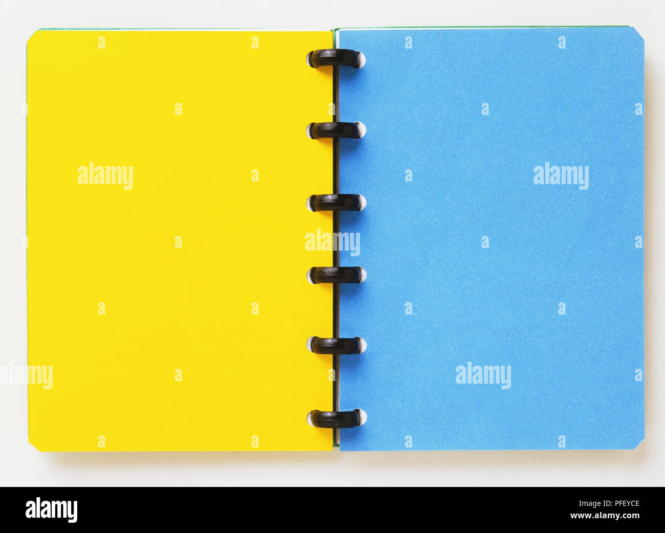 Open spiral-bound notebook, showing a yellow and a blue page Stock ...