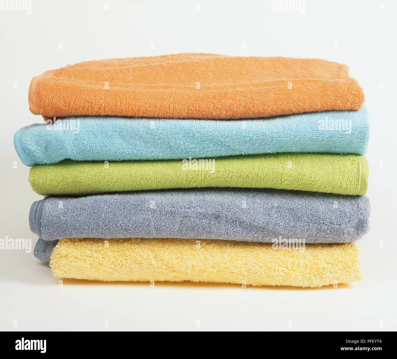 Pile of folded, different coloured towels Stock Photo - Alamy