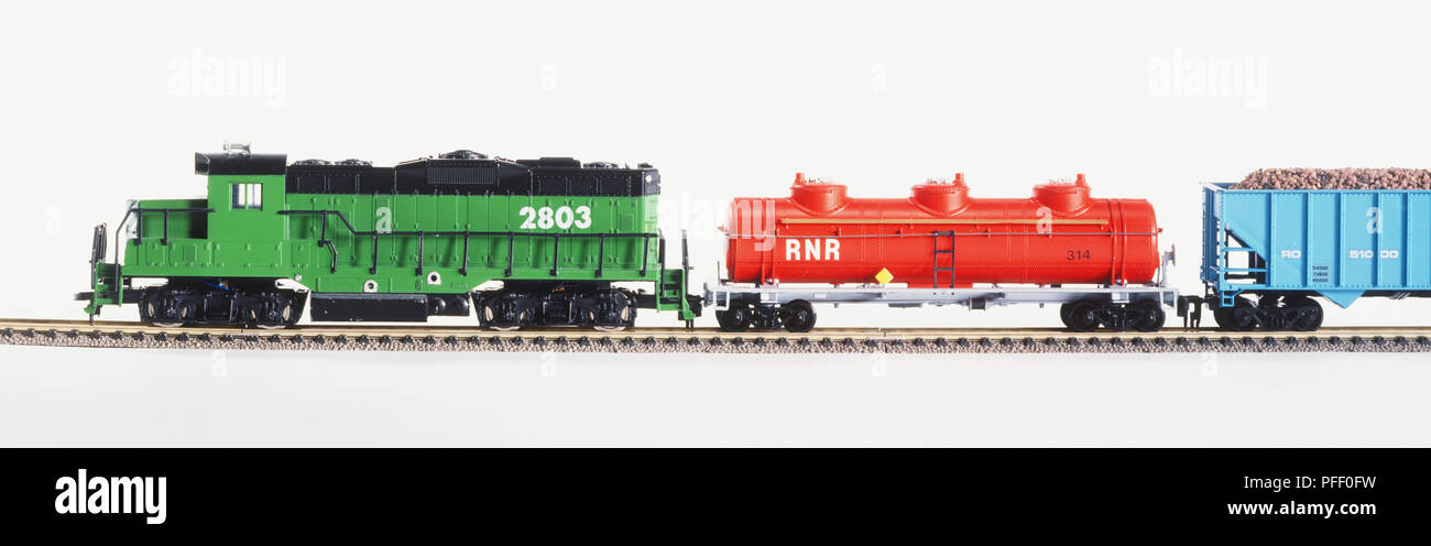 Toy train, consisting of a green engine, and red and blue carriages ...