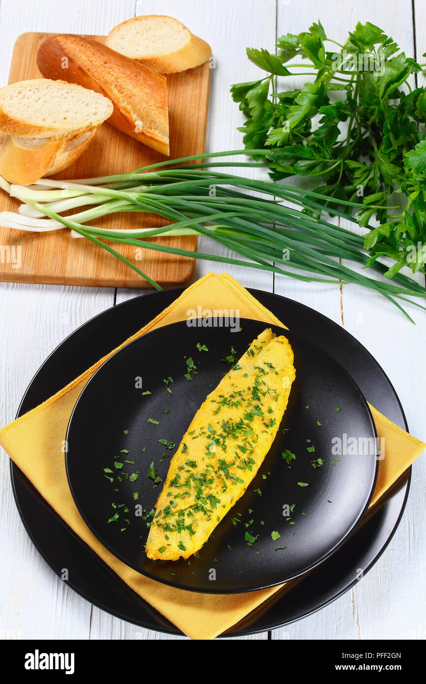 delicious French tender omelette served on black plates with yellow ...