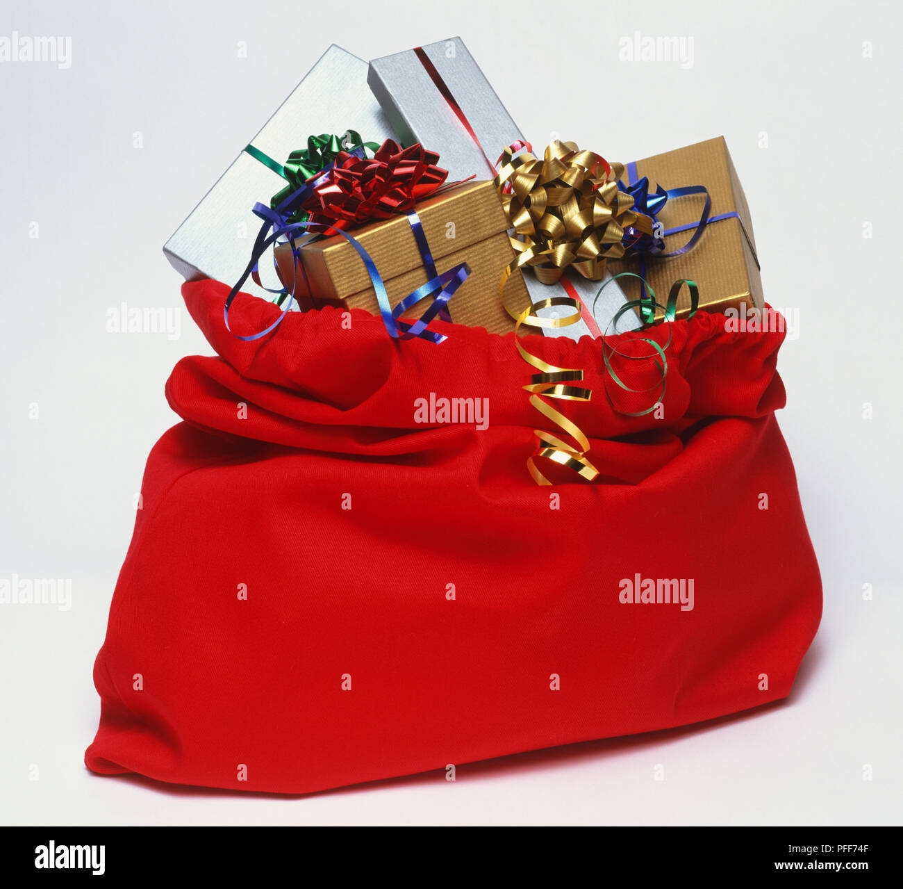 A red sack full of Christmas presents Stock Photo - Alamy