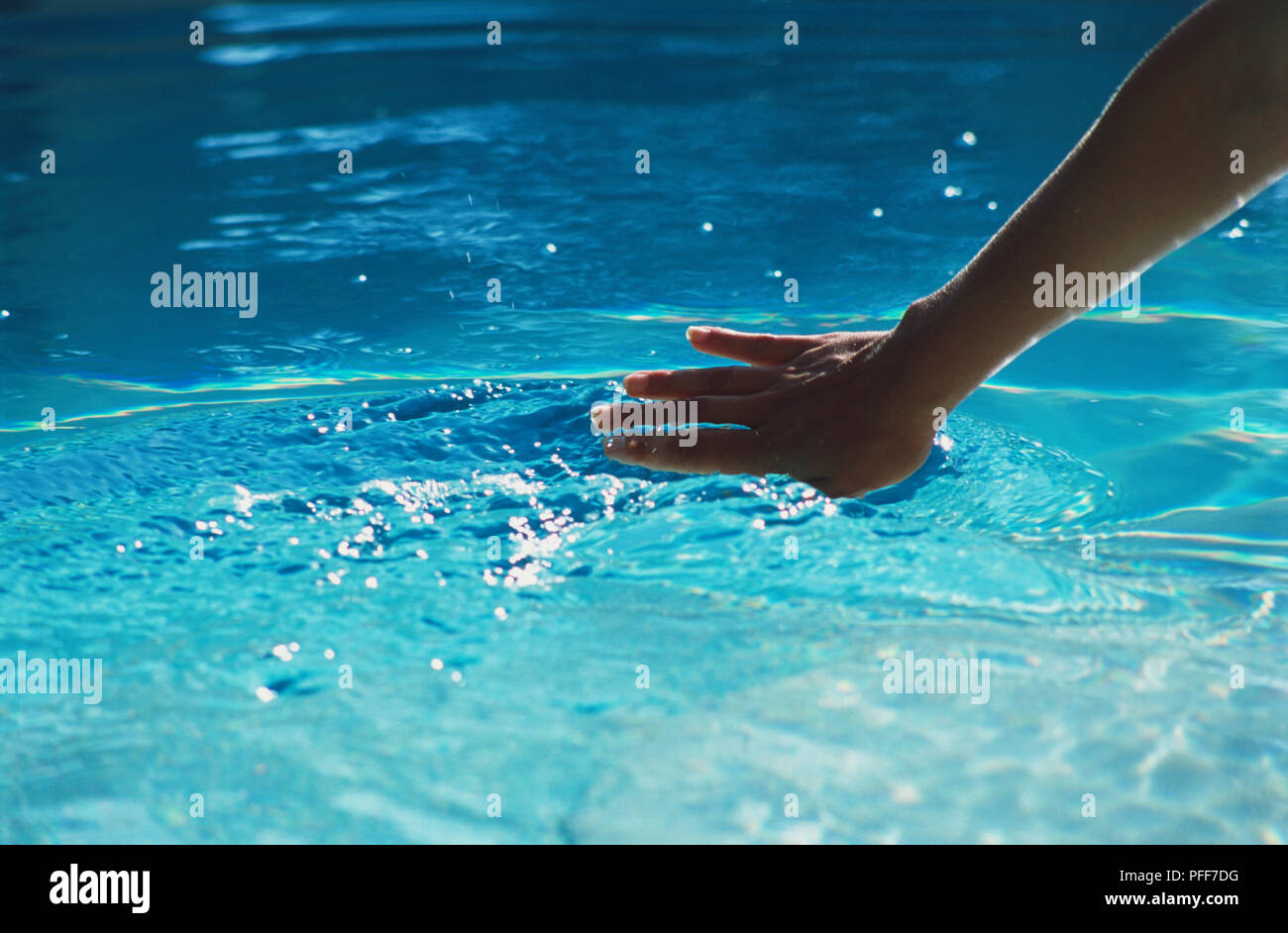 Womans hand pushing water creating ripples, close up Stock Photo - Alamy