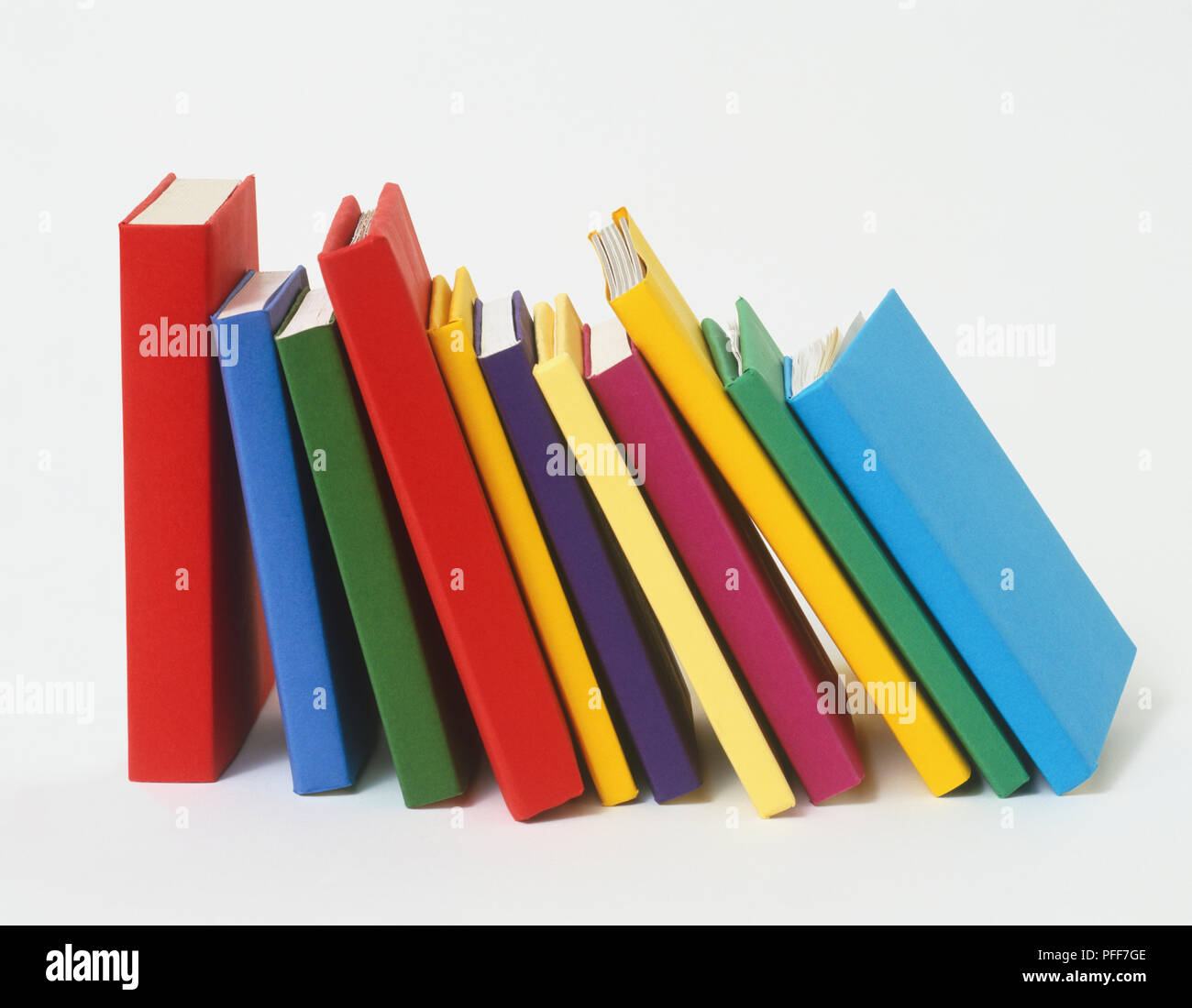Row of colourful books leaning against each other Stock Photo - Alamy