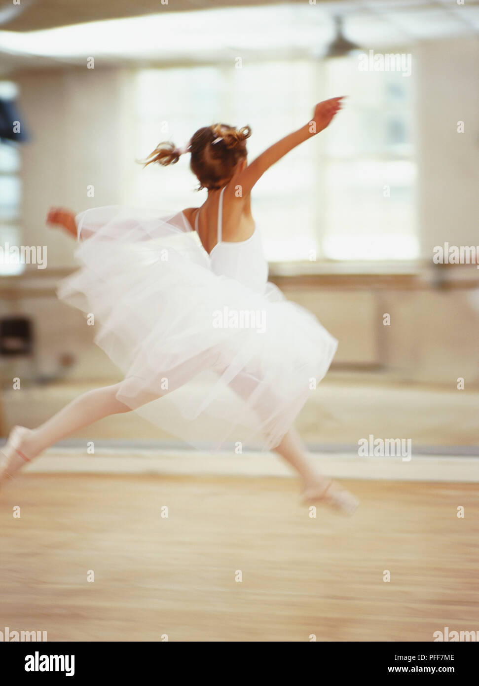 Young ballet dancer wearing white leotard and long tutu leaping Stock ...