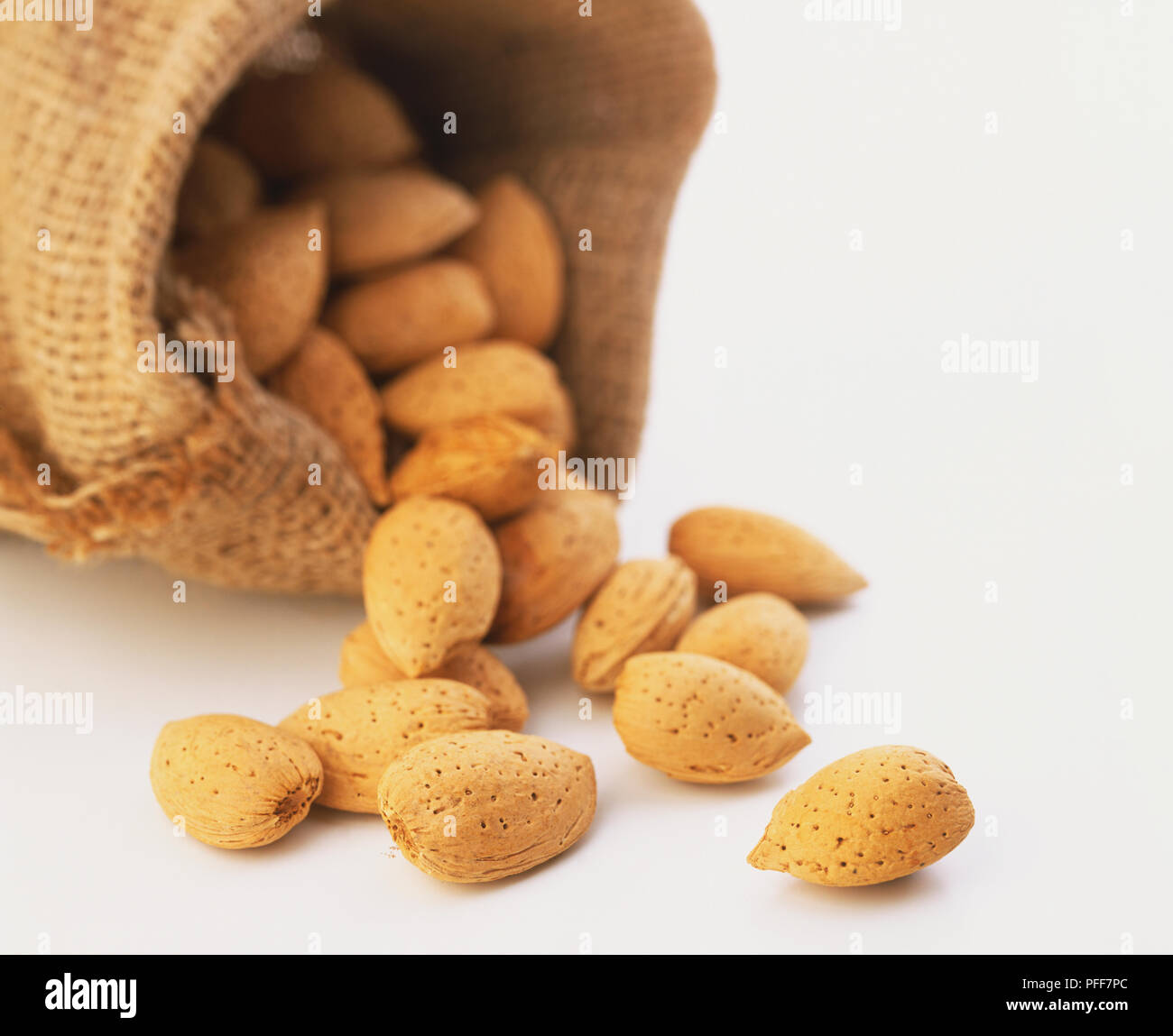 Whole almonds pouring from a hessian sack Stock Photo - Alamy