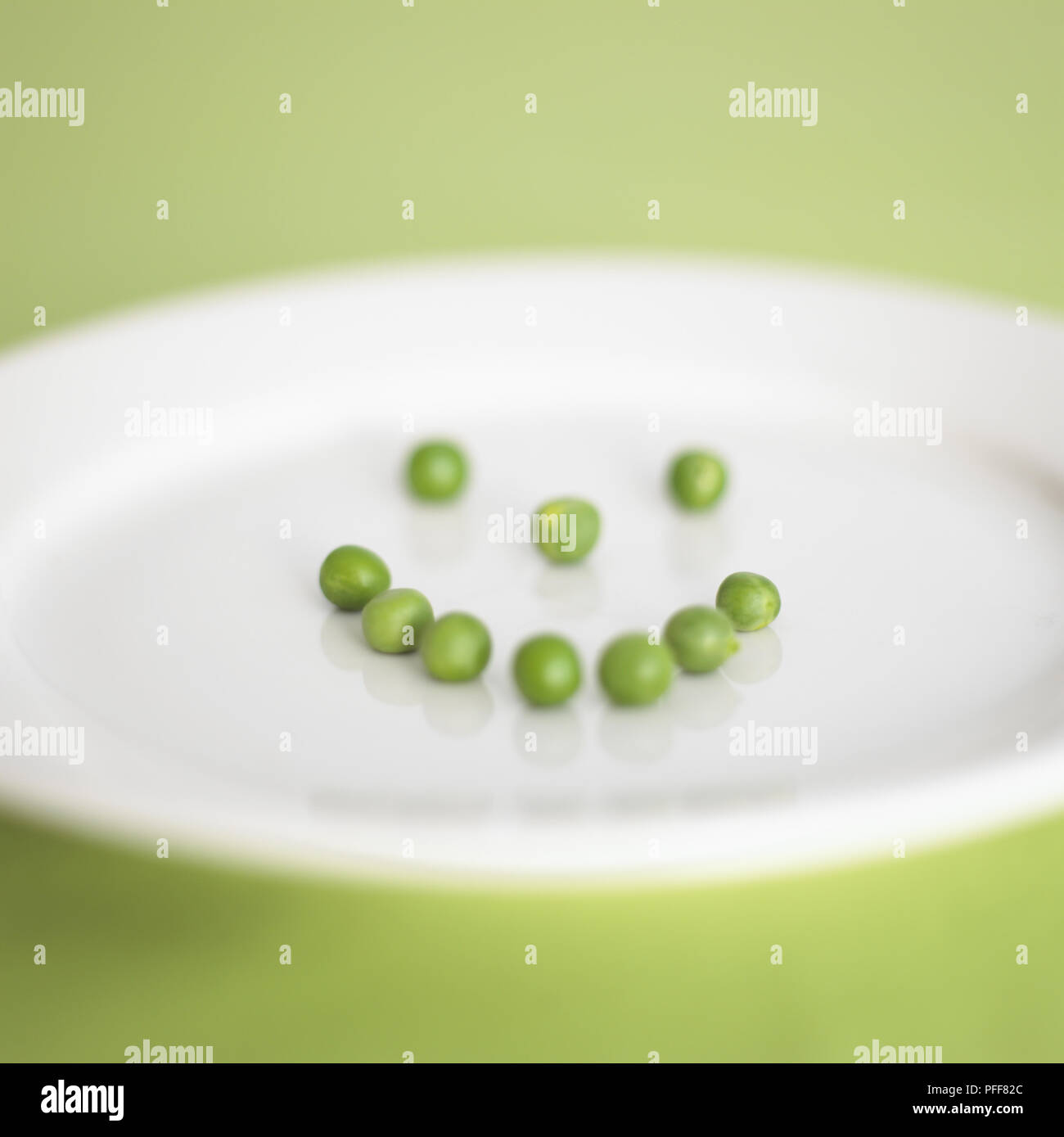 Peas arranged on a plate in the shape of a smiley face, close up Stock ...