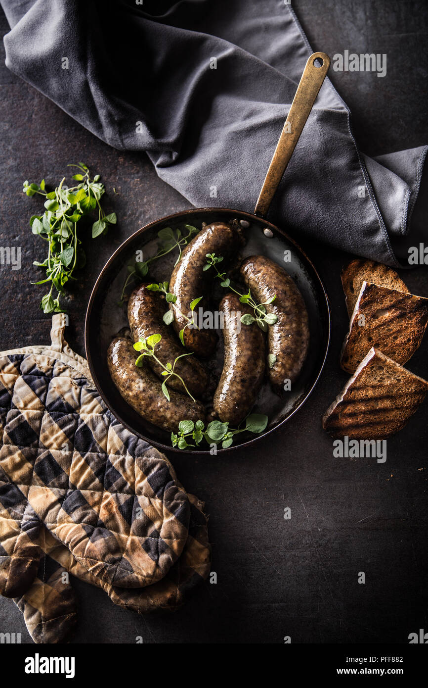 Roasted sausages in pan with bread and herbs. Traditional european food ...