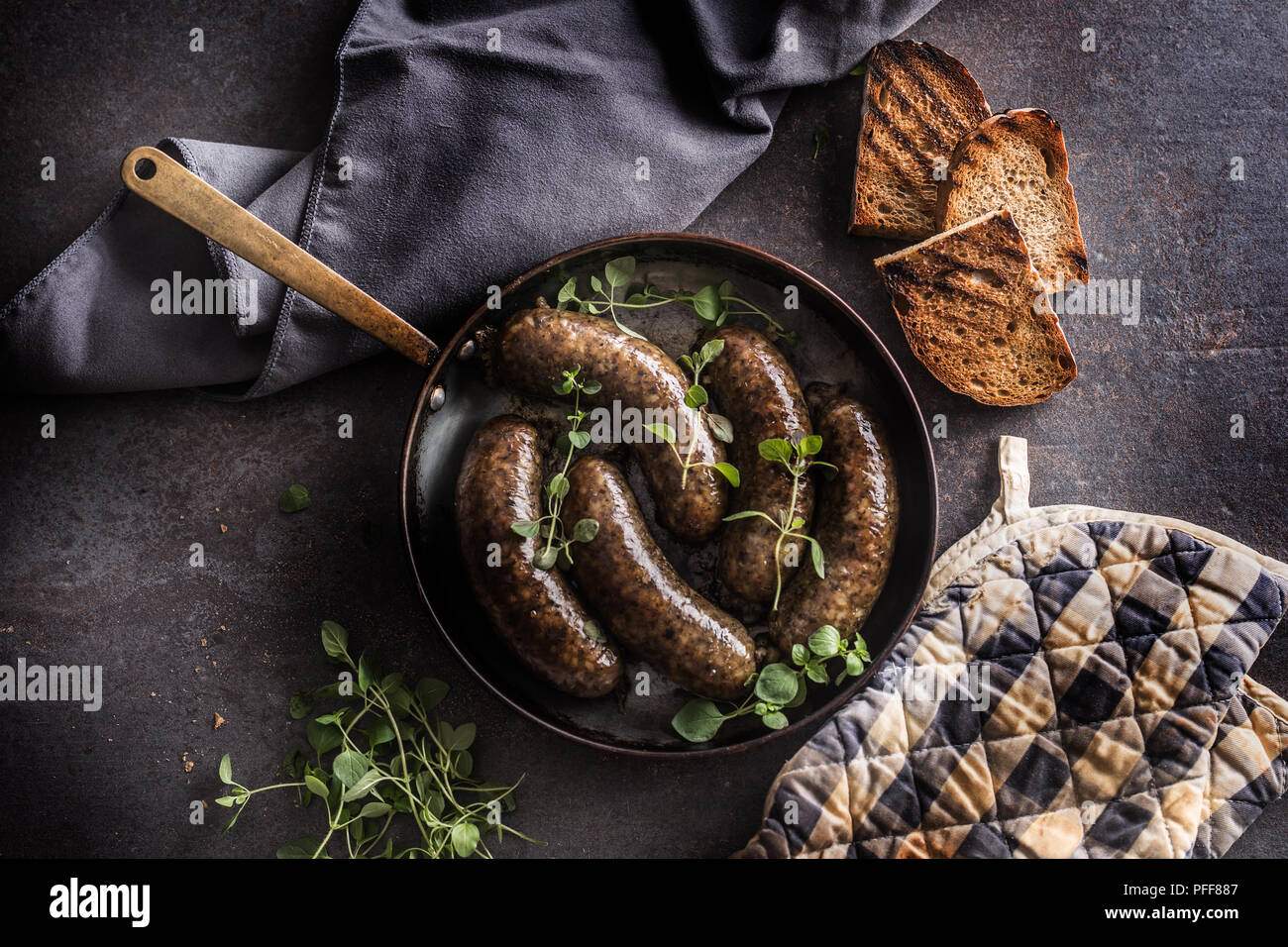 Roasted sausages in pan with bread and herbs. Traditional european food ...