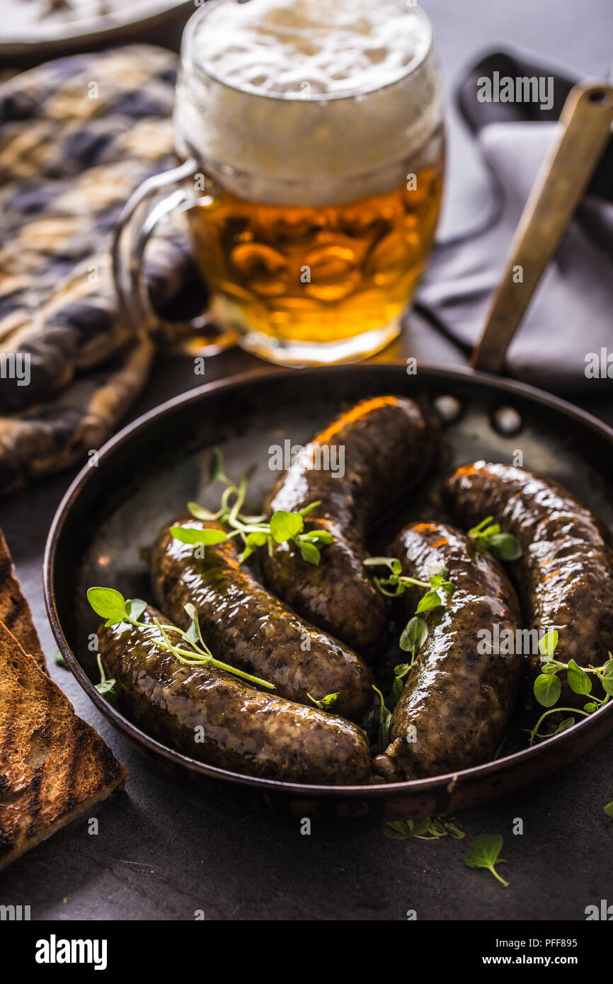 Roasted sausages in pan with bread herbs and draft beer. Traditional ...