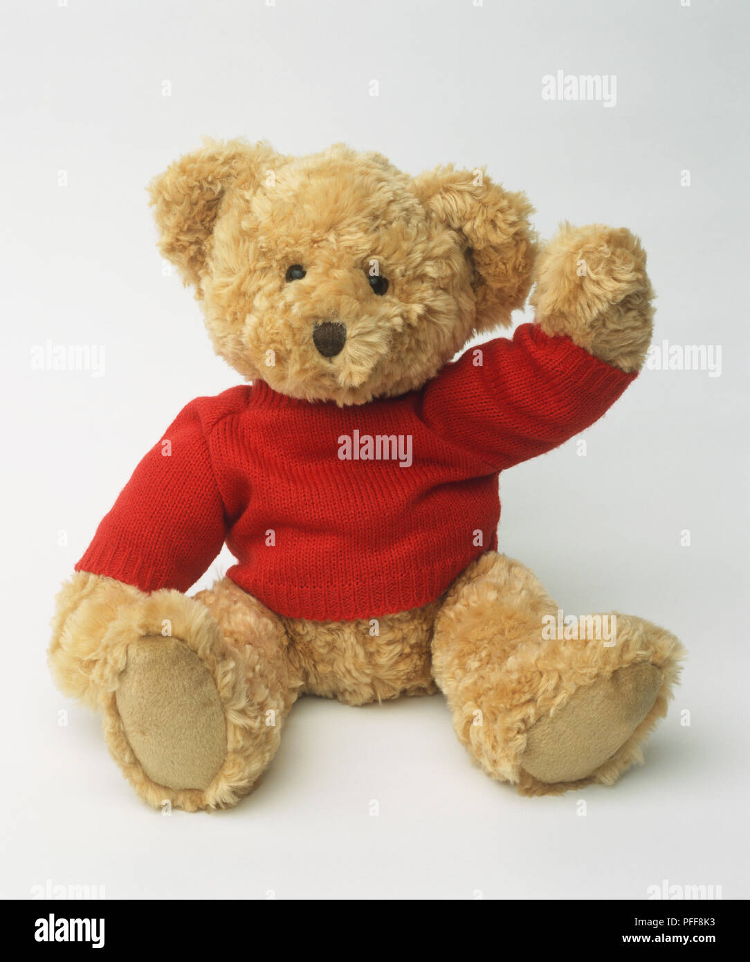 Teddy bear in red clothes, one arm raised, front view Stock Photo - Alamy