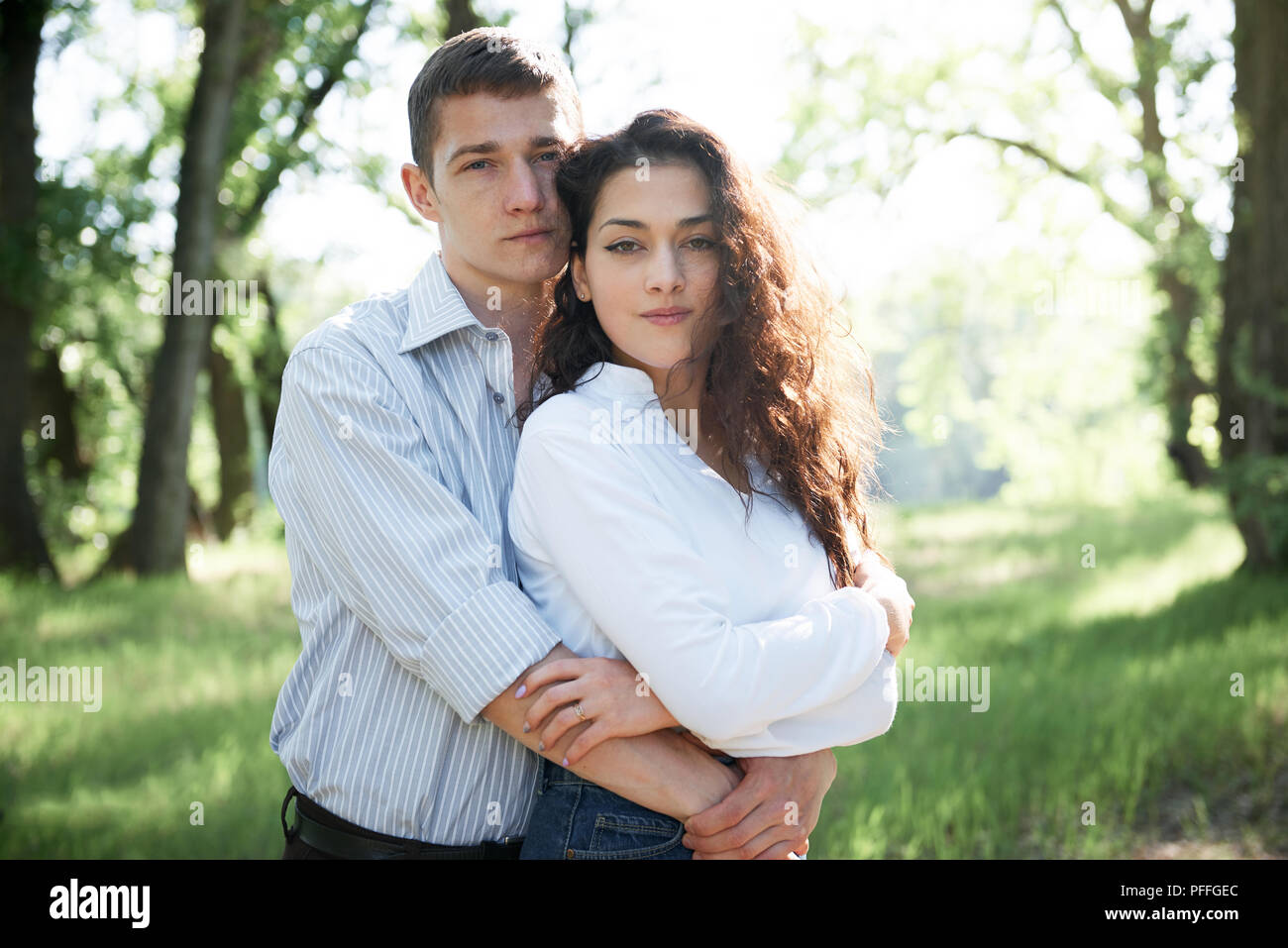 young couple walking in the forest, summer nature, bright sunlight ...