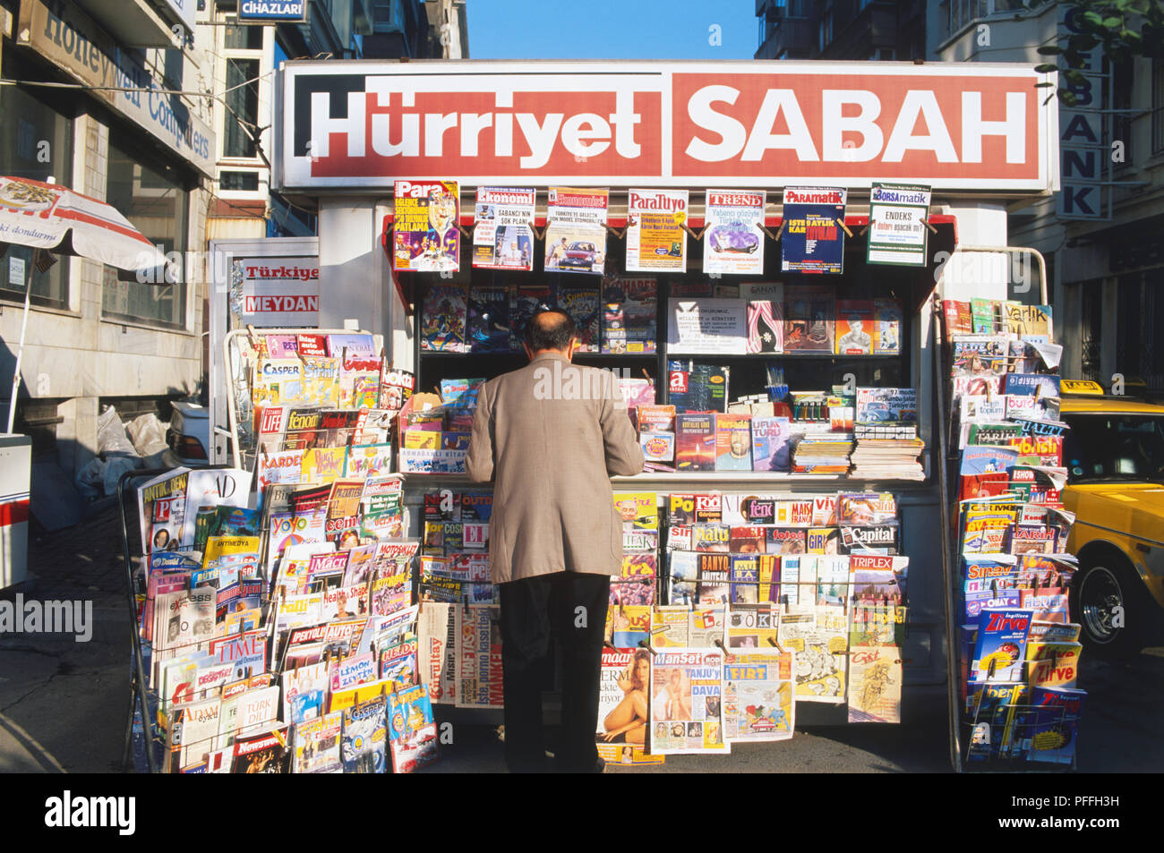 Turkey, Istanbul, man being served at a newspaper stand, view from ...