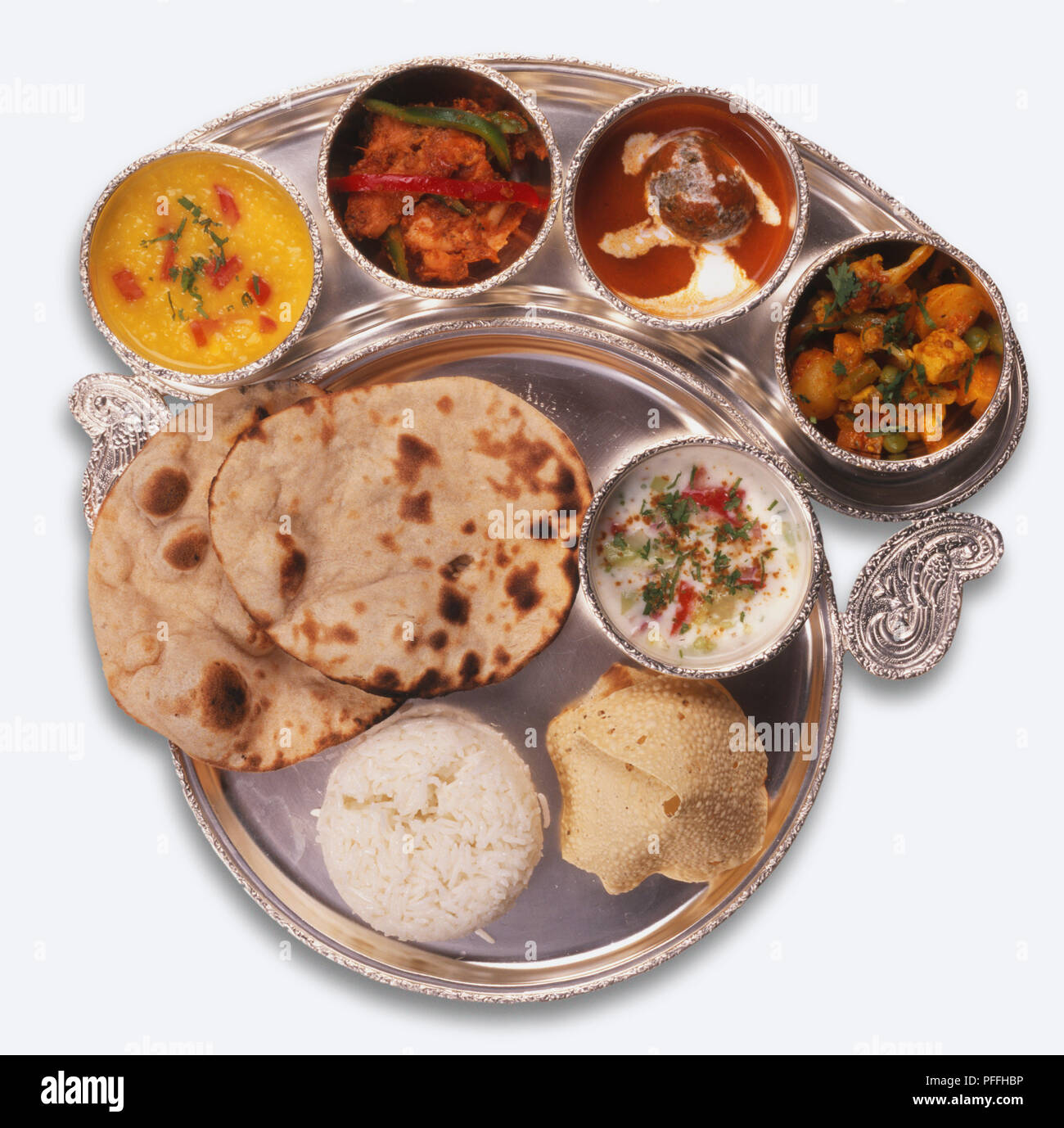 Indian Thali served on a silver platter, containing large round Roti ...