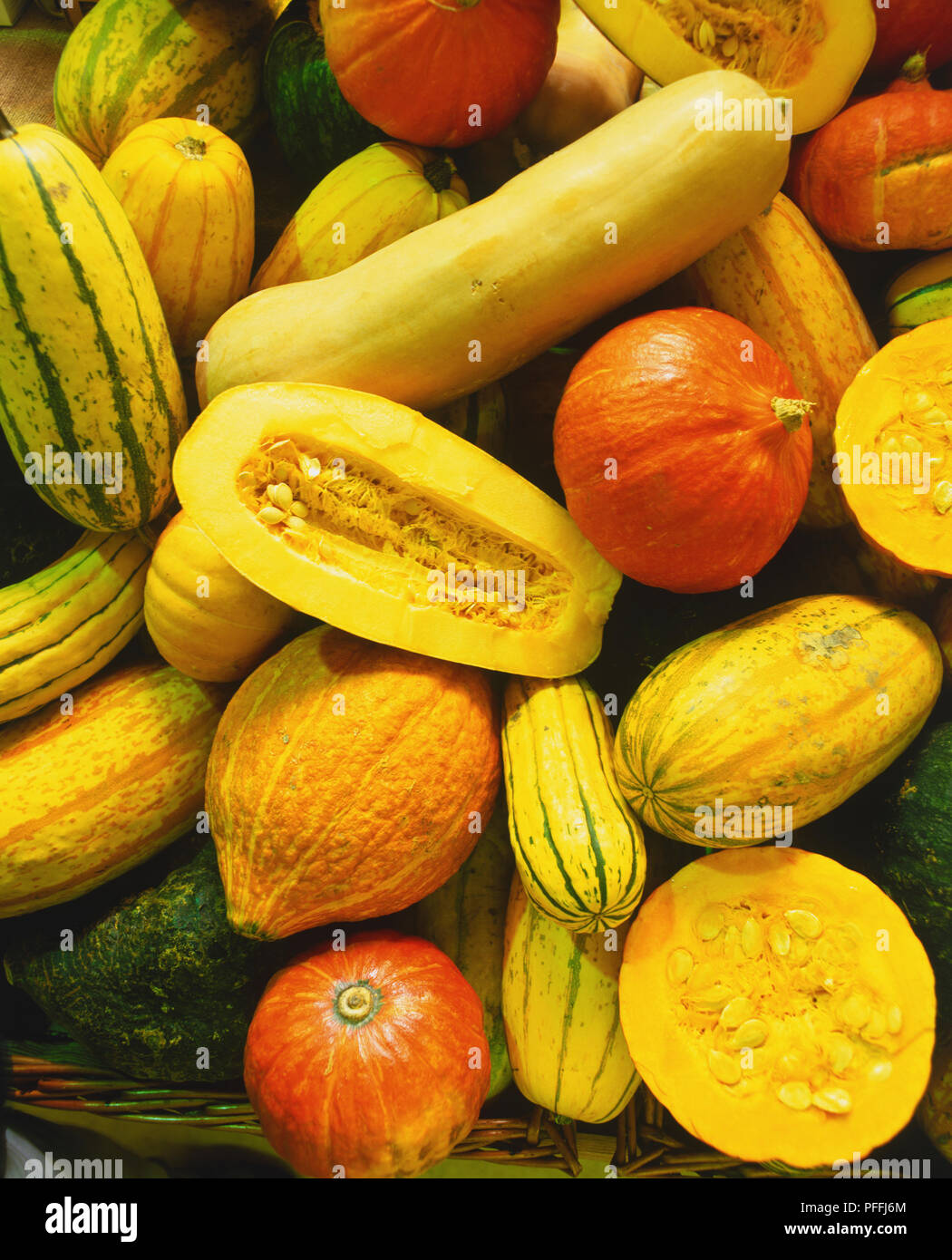 Close-up of whole pumpkins and other squashes, one sliced in half ...