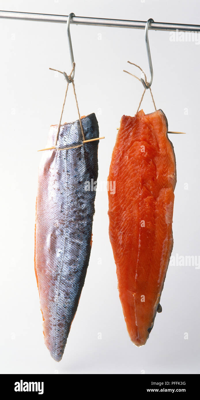 Two fillets of salmon hanging on hooks, front and rear view Stock Photo ...