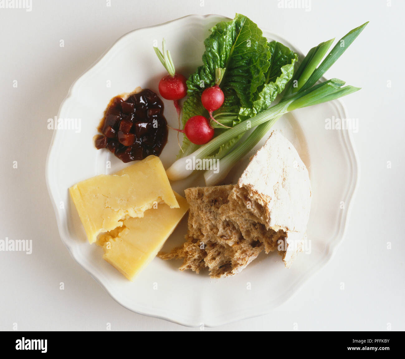 Ploughman's lunch plate with pieces of cheese, spring onions, radishes ...