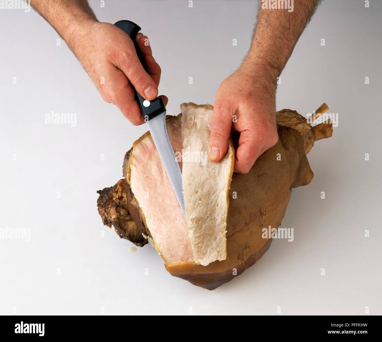 Using kitchen knife to remove skin from cured ham Stock Photo - Alamy