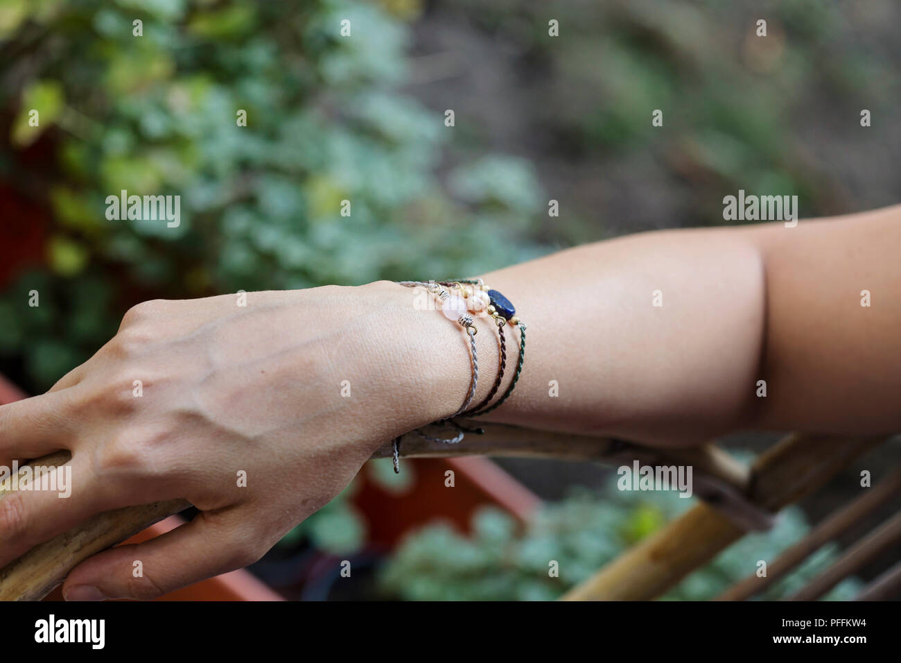 Female hand wrist resting with tiny jewelry Stock Photo - Alamy