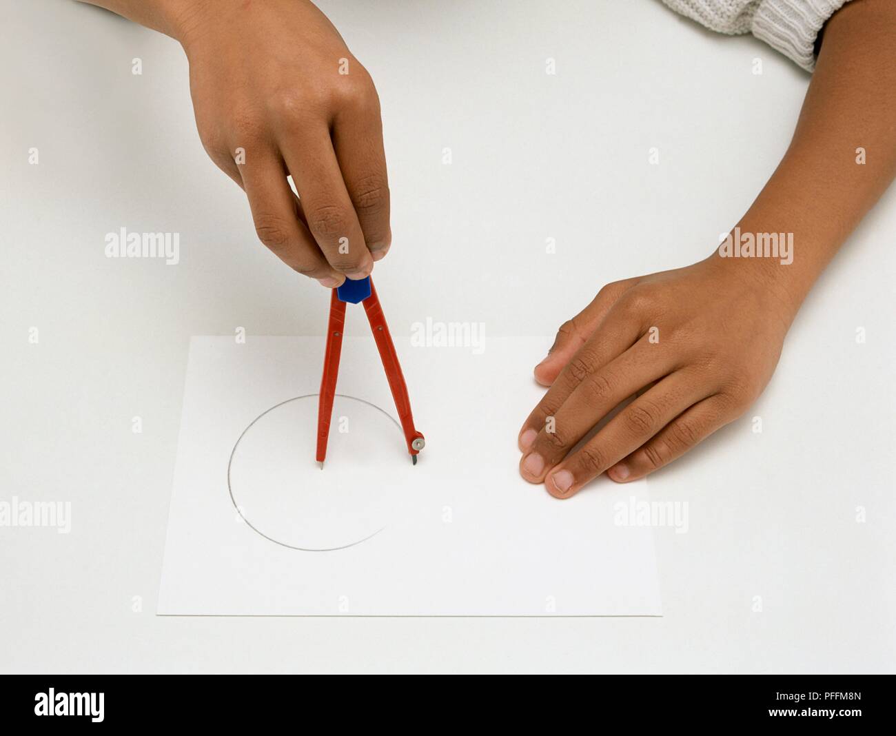 Boy's hands drawing circle on card using pair of compasses Stock Photo ...