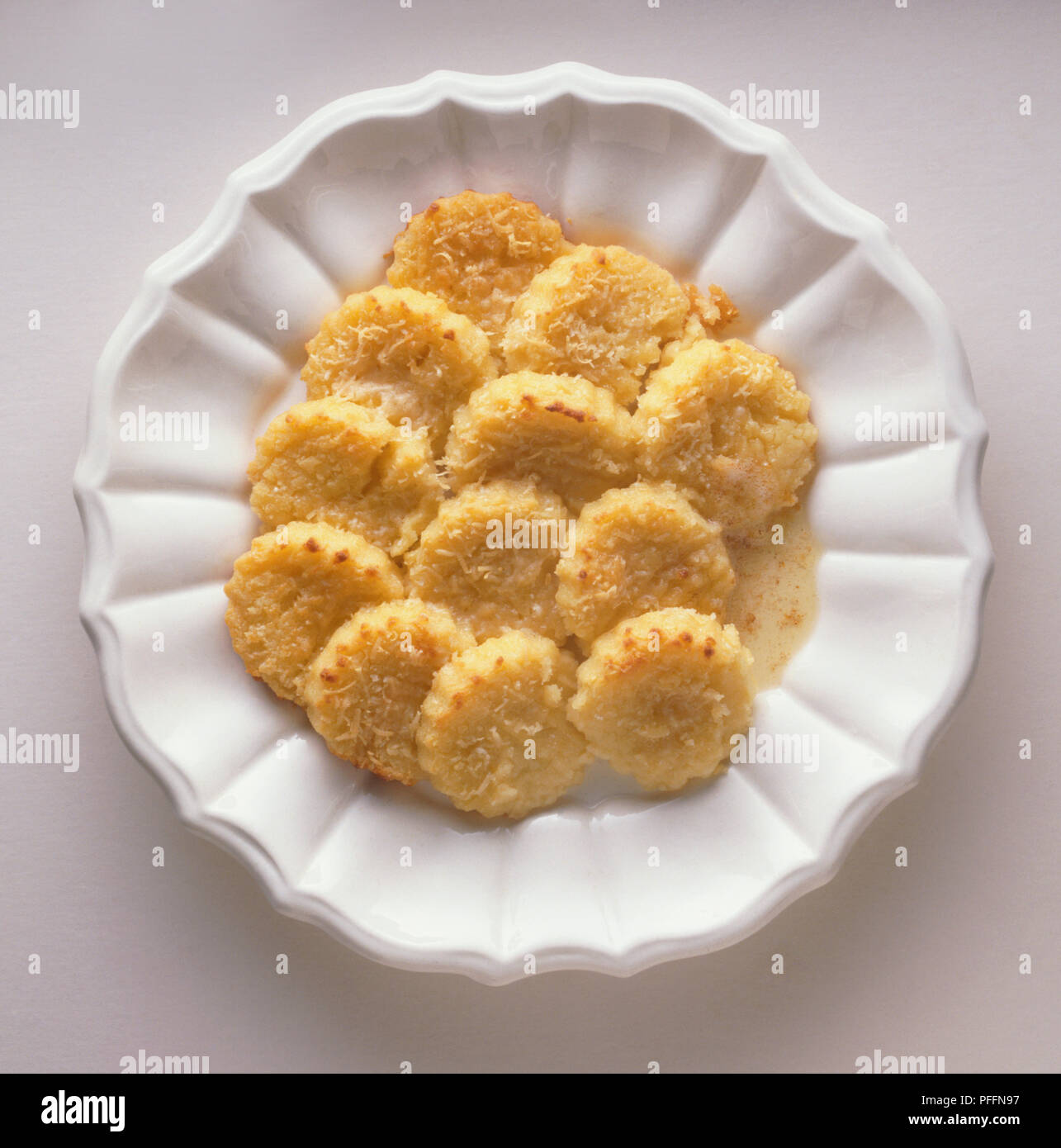 Plate of Gnocchi alla Romana, semolina dumplings served with butter, a ...