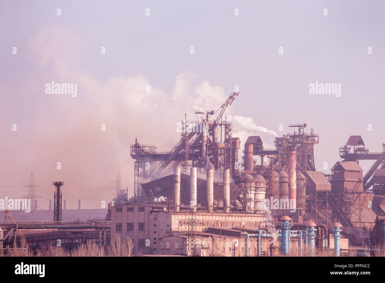 smoke stacks in a working factory emitting steam, smog and air ...