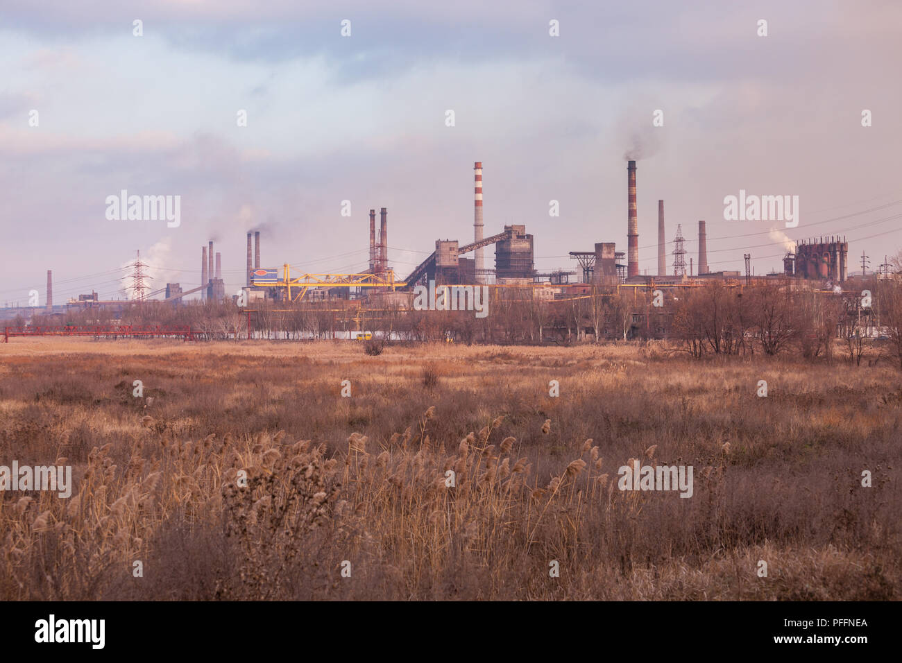 smoke stacks in a working factory emitting steam, smog and air ...