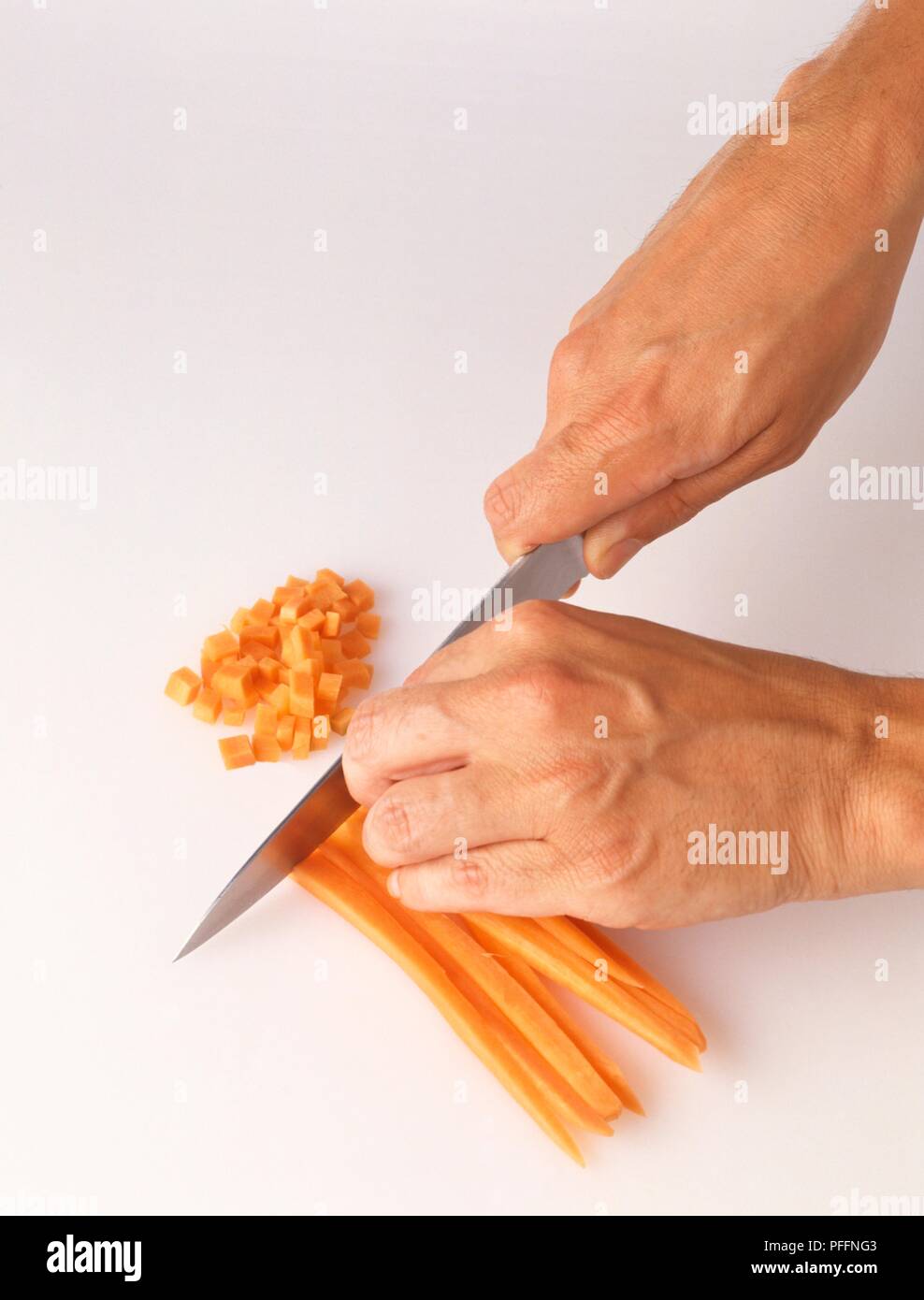 Using kitchen knife to dice carrots Stock Photo - Alamy