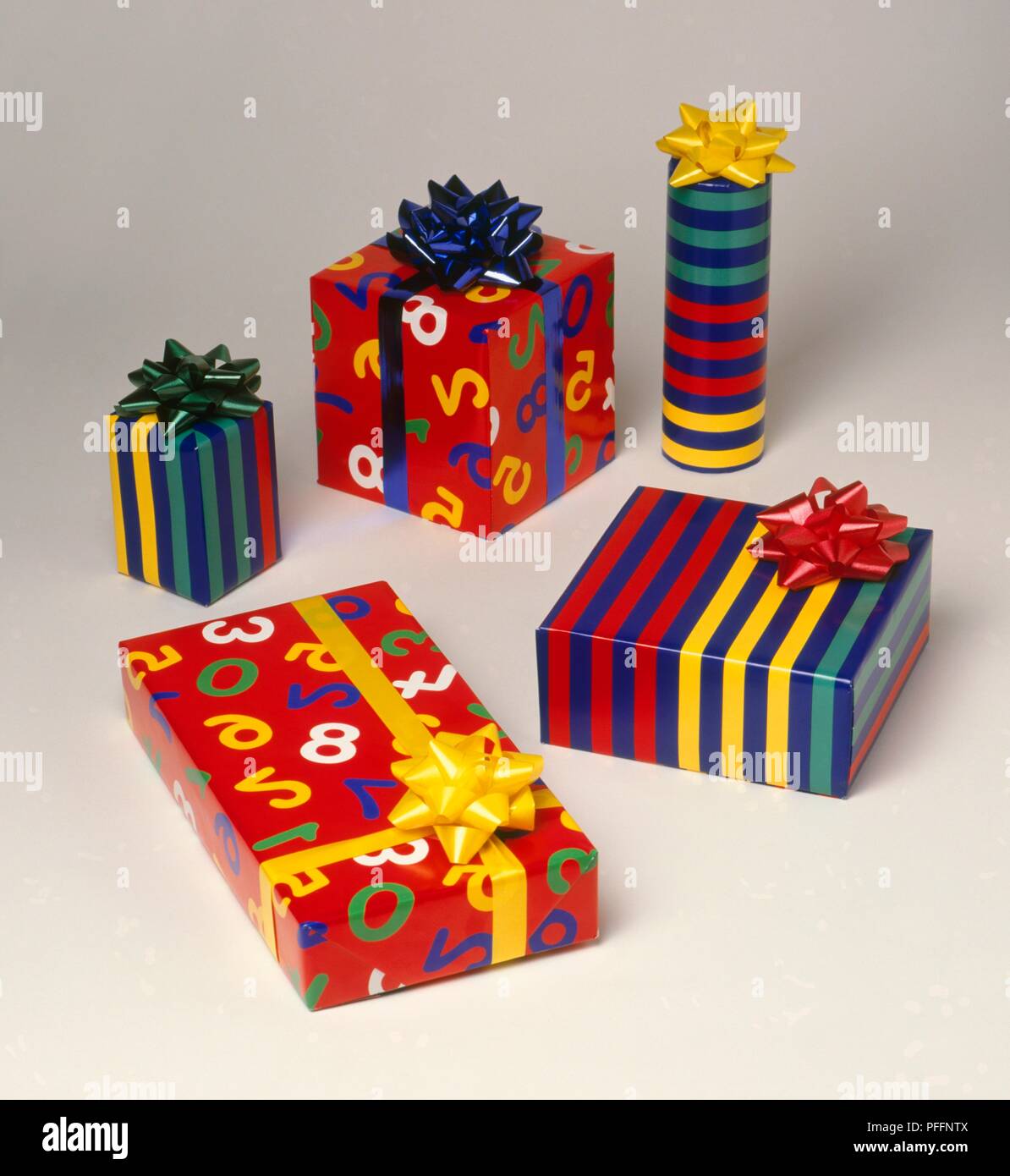 Five birthday presents covered in patterned wrapping paper and tied ...