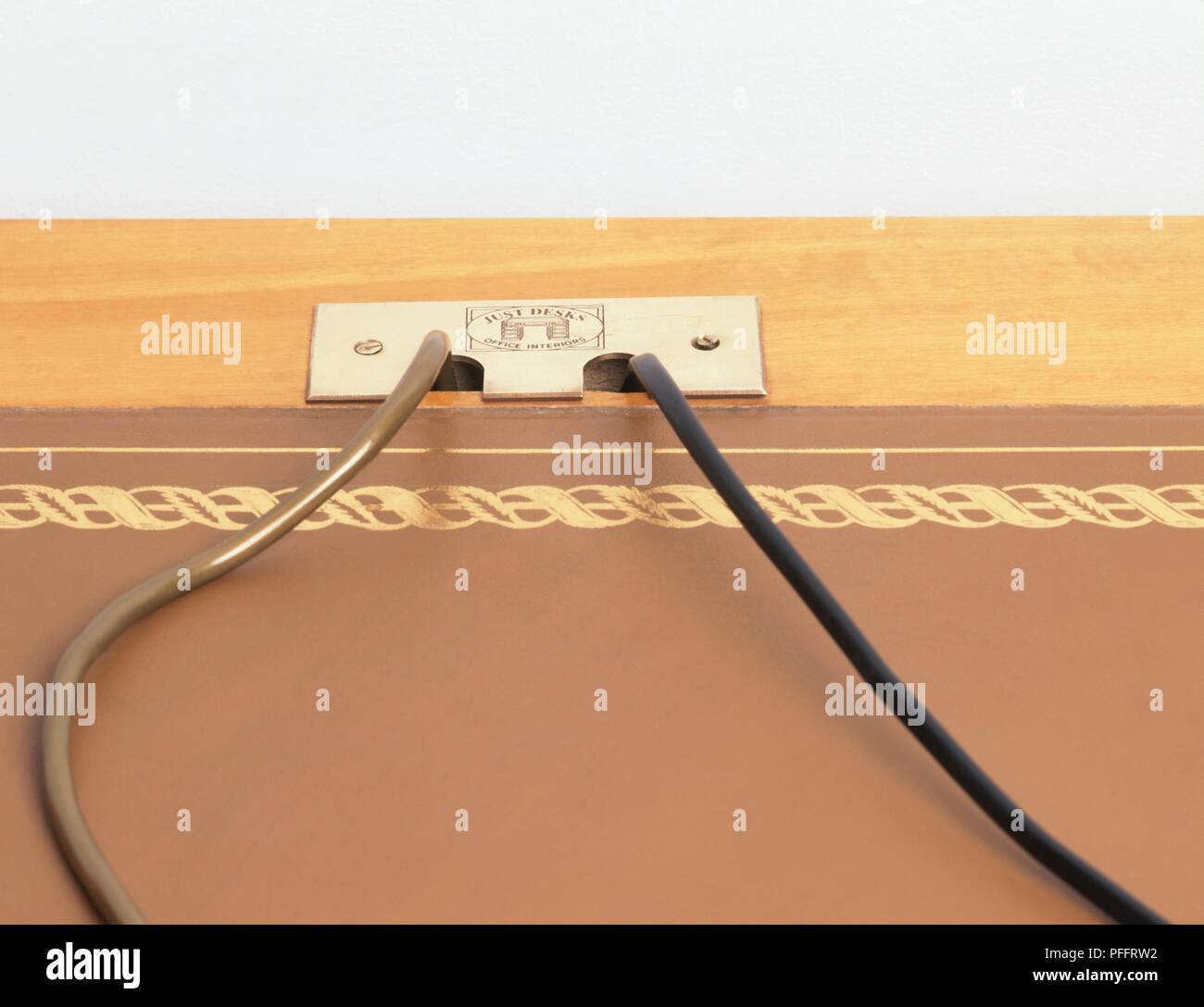 Two electric cables running into a wooden desk at a cable point Stock ...