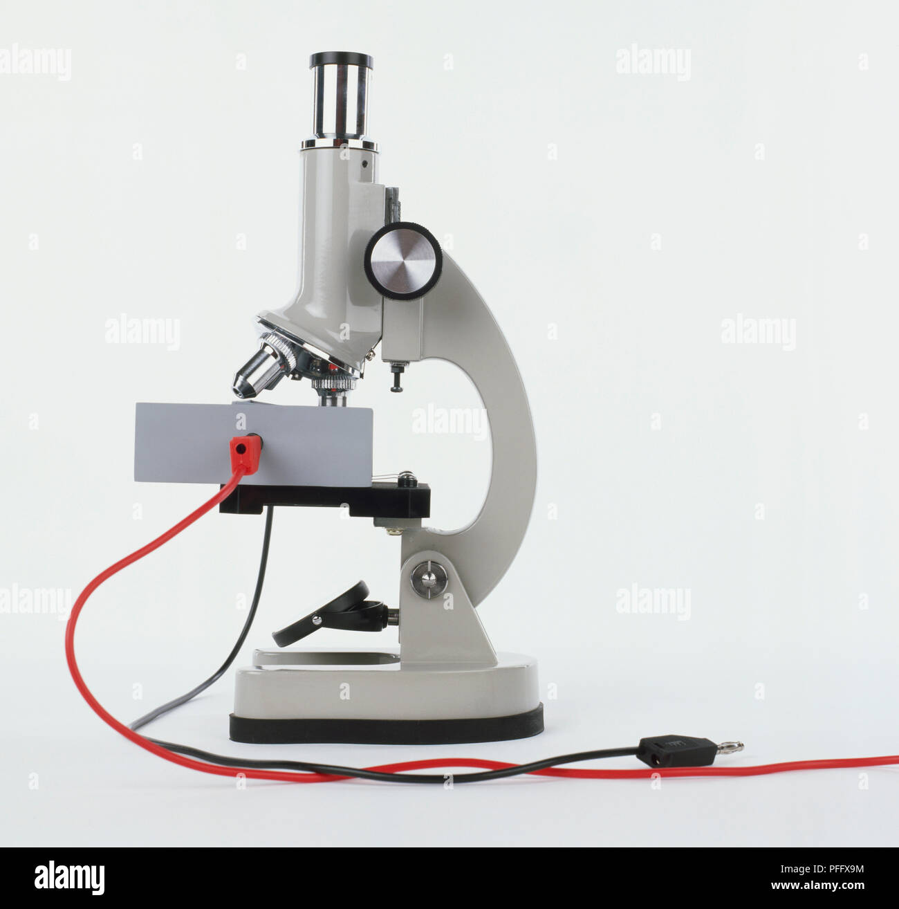 Side view of a microscope with red and black wires Stock Photo - Alamy